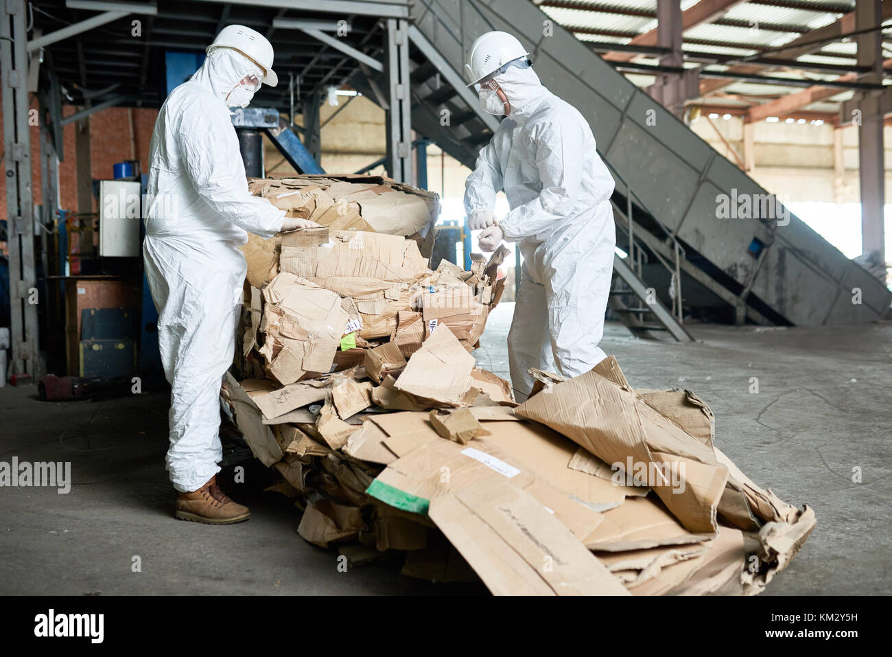Workers in Hazmat Suits Sorting Cardboard at Modern Factory Stock Photo ...
