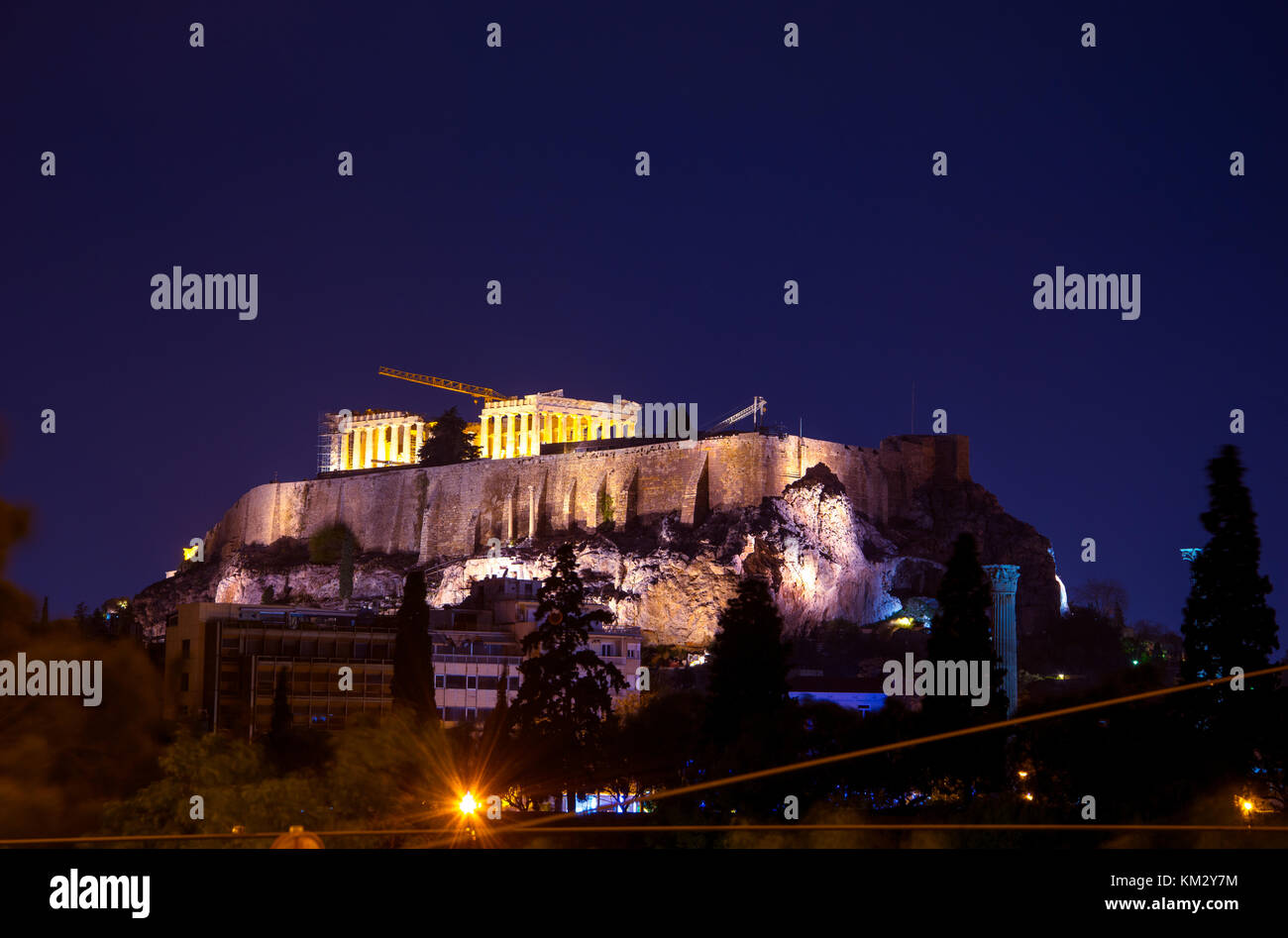 Illuminated Acropolis with Parthenon at night with the hill of Lycabetus and nice clouds, Greece ...