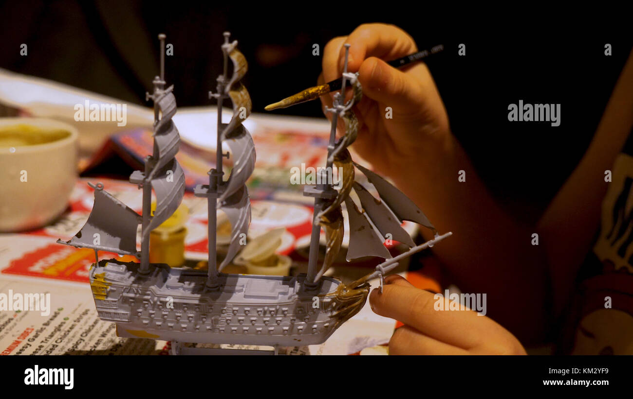 Boy hands assembling plastic model kit of ship at home. Hobby and ...