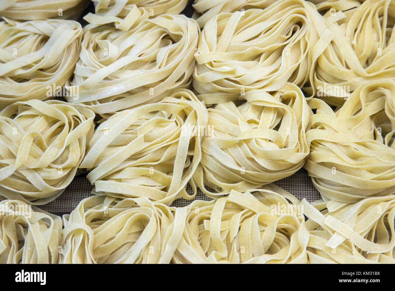 Fresh uncooked tagliatelle pasta noodles on display in market Stock ...