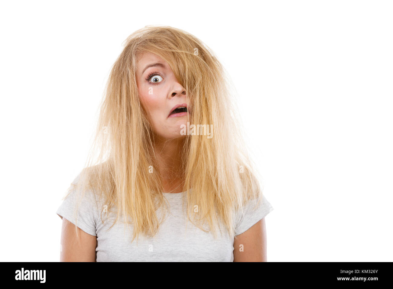 Bad hairstyle concept. Crazy, mad blonde woman with messy hair looking ...