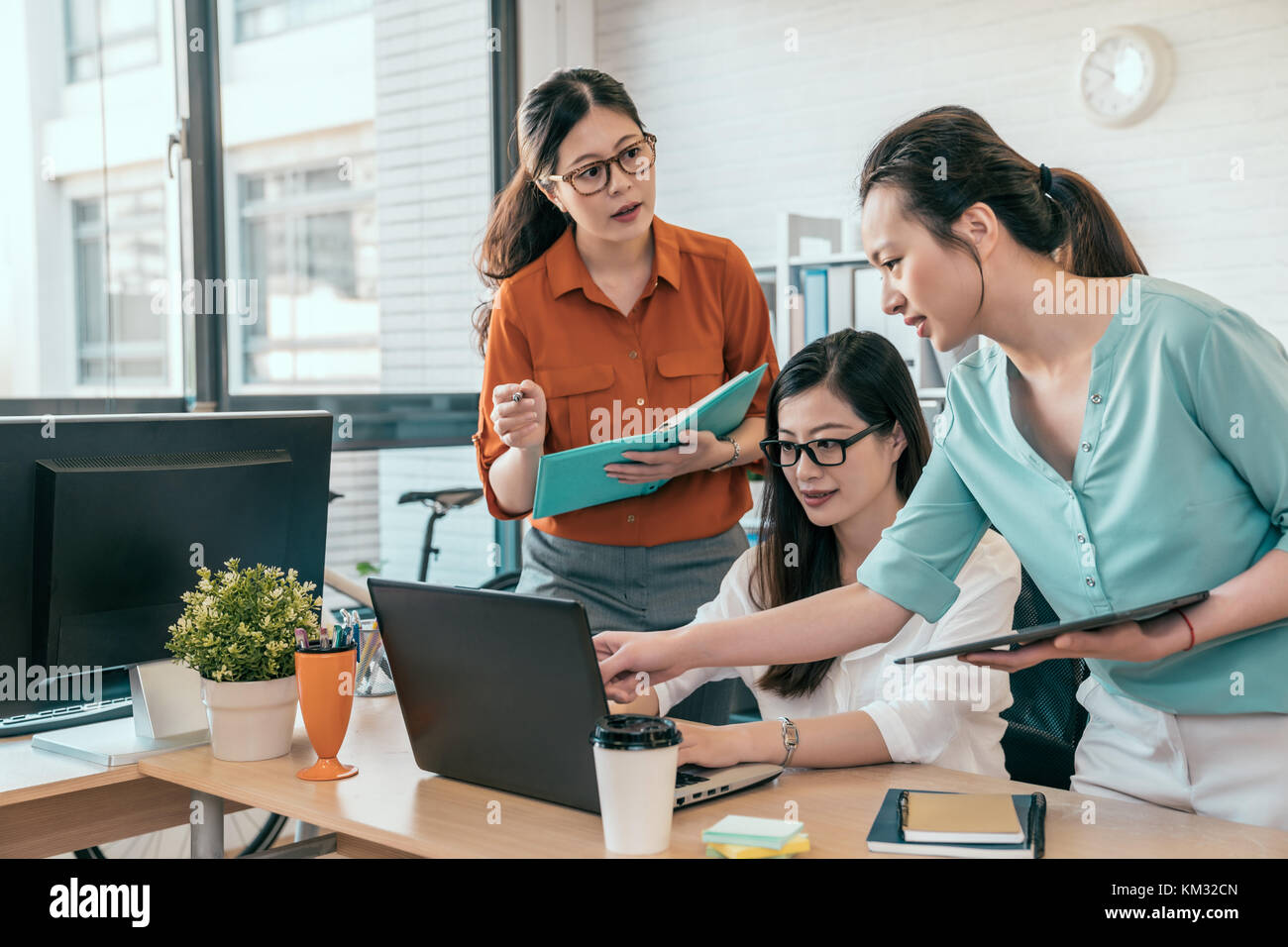 Group of young cheerful business Asian people working and communicating ...