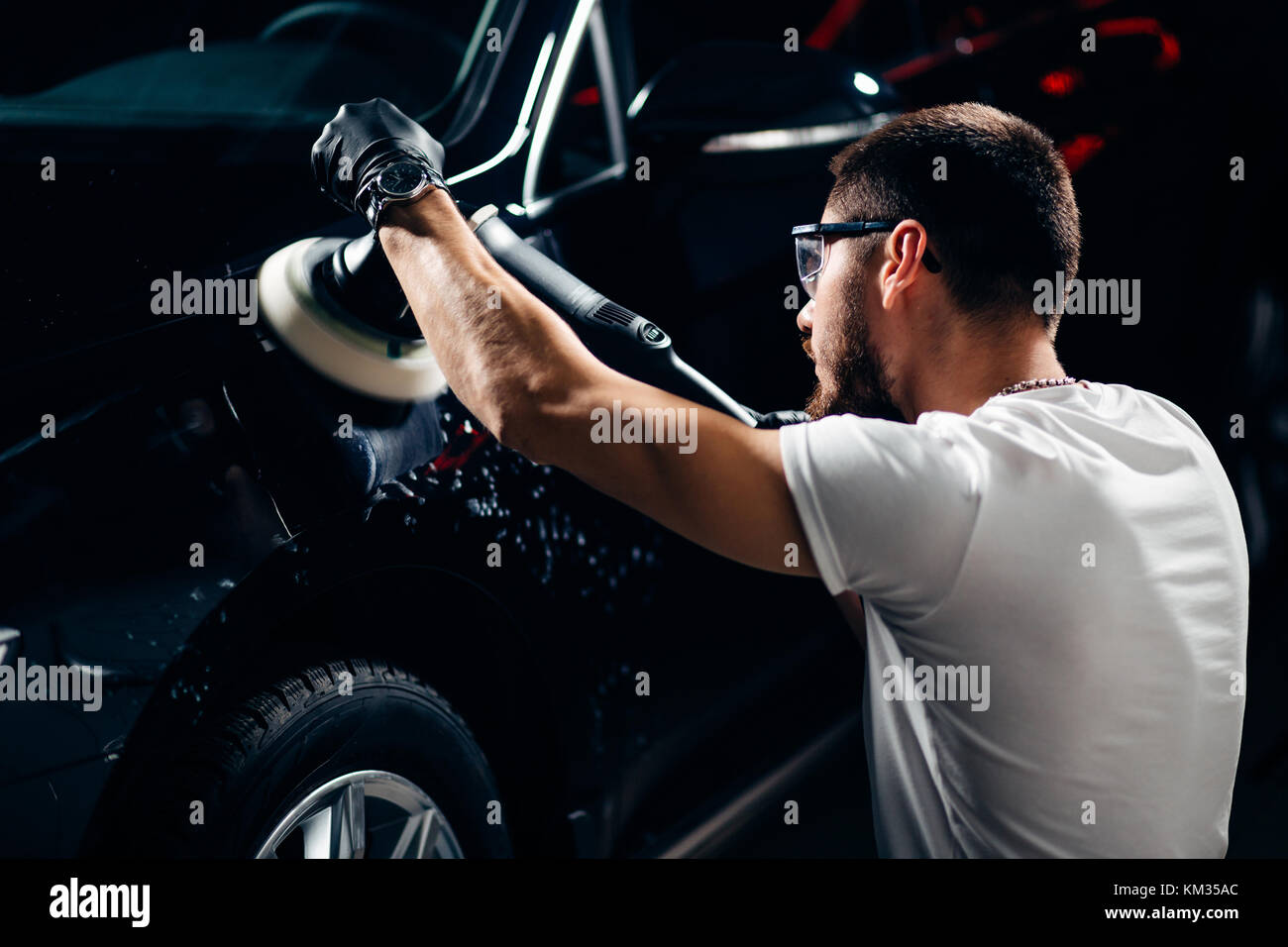 Car detailing - man with orbital polisher in auto repair shop ...