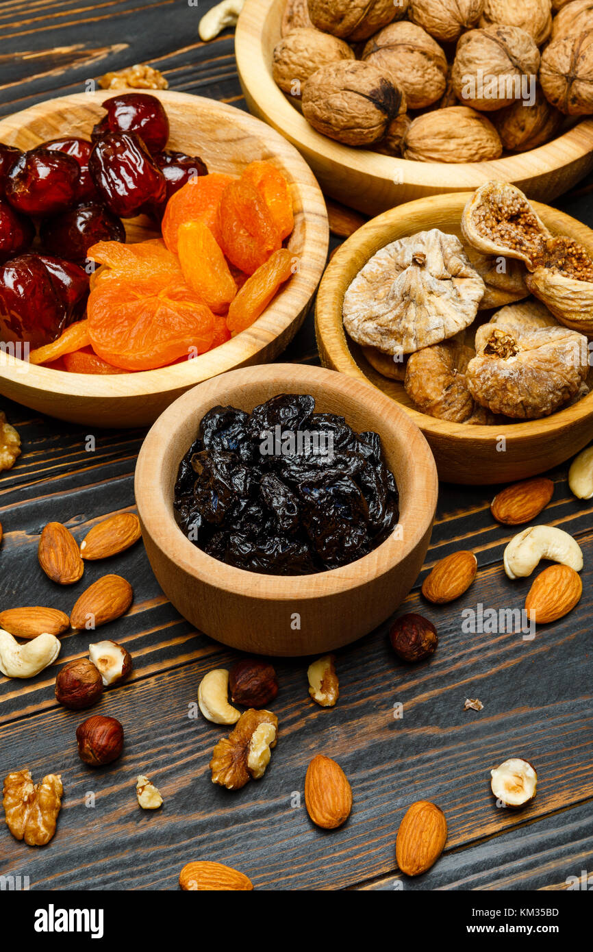 dried fruits figs, apricots, plums and nuts on wooden background Stock ...