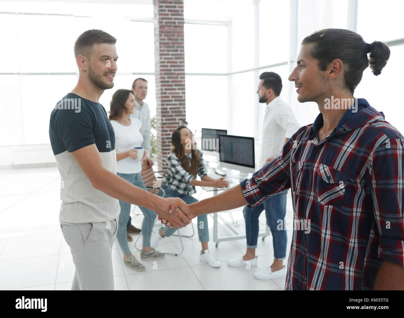 handshake colleagues in creative office Stock Photo - Alamy