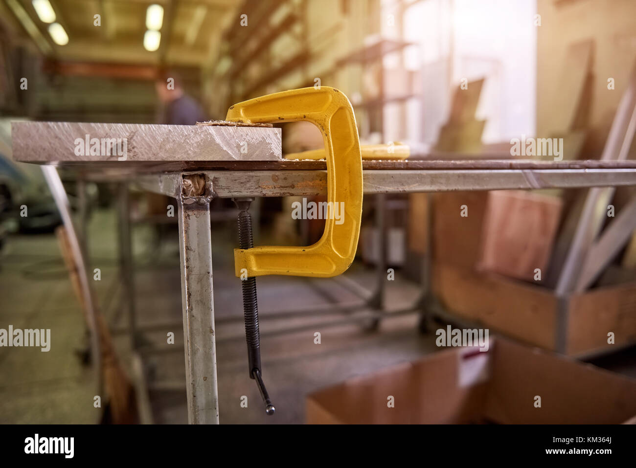 C-clamp is clamping a metal plate to a table Stock Photo - Alamy