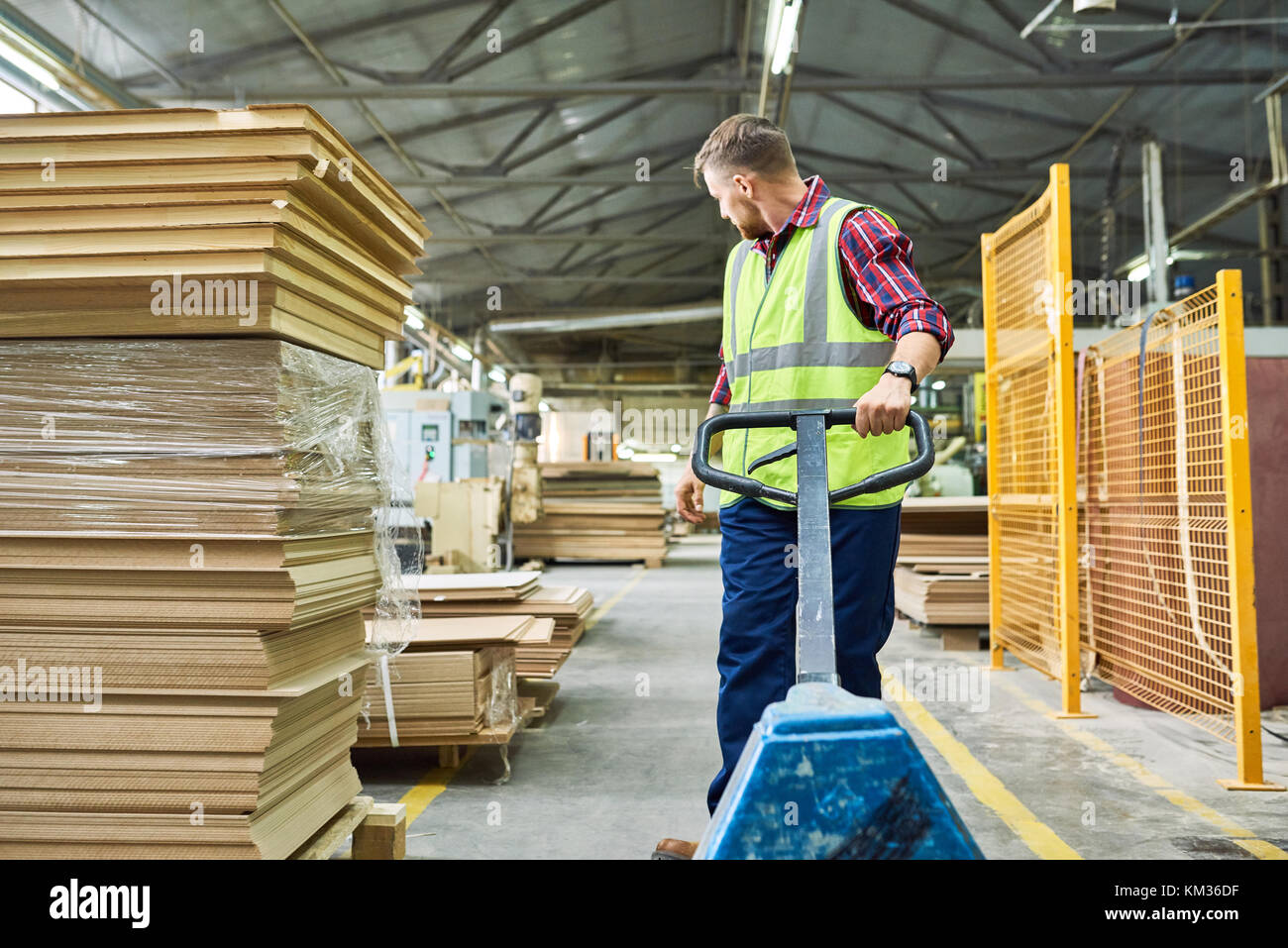 Young Man Moving Wooden Boards in Warehouse Stock Photo - Alamy