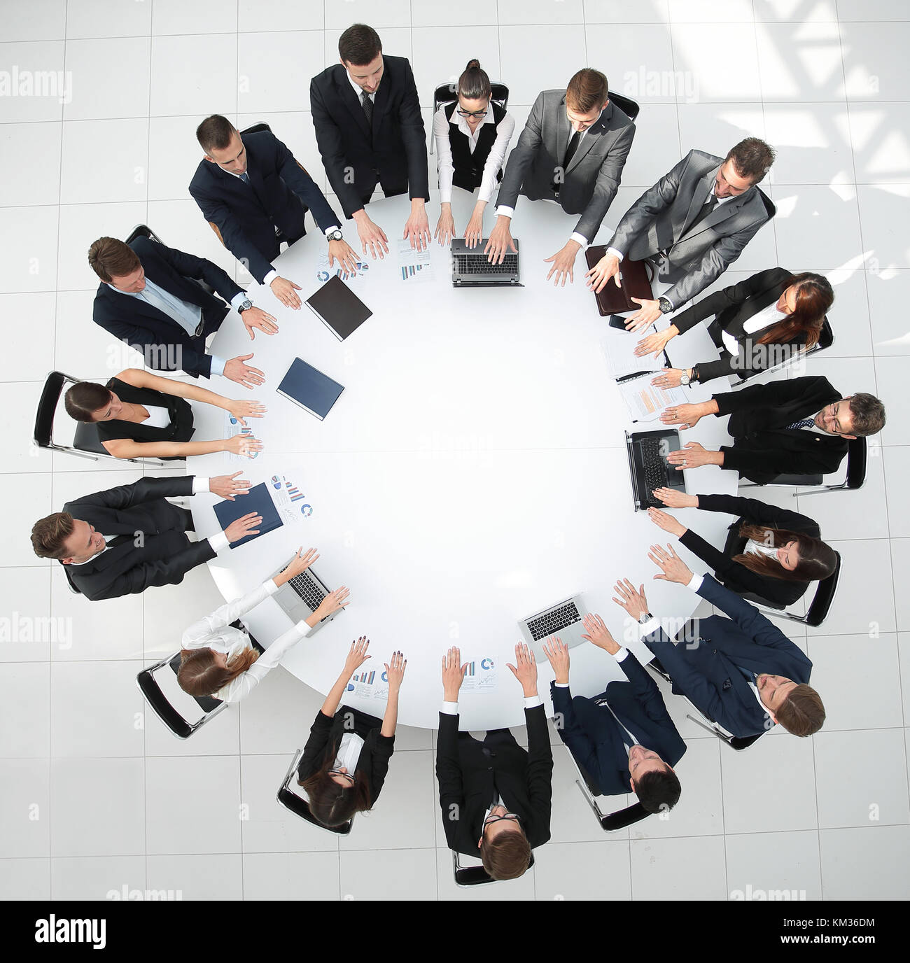 group of business people sitting at the round table, and putting his ...