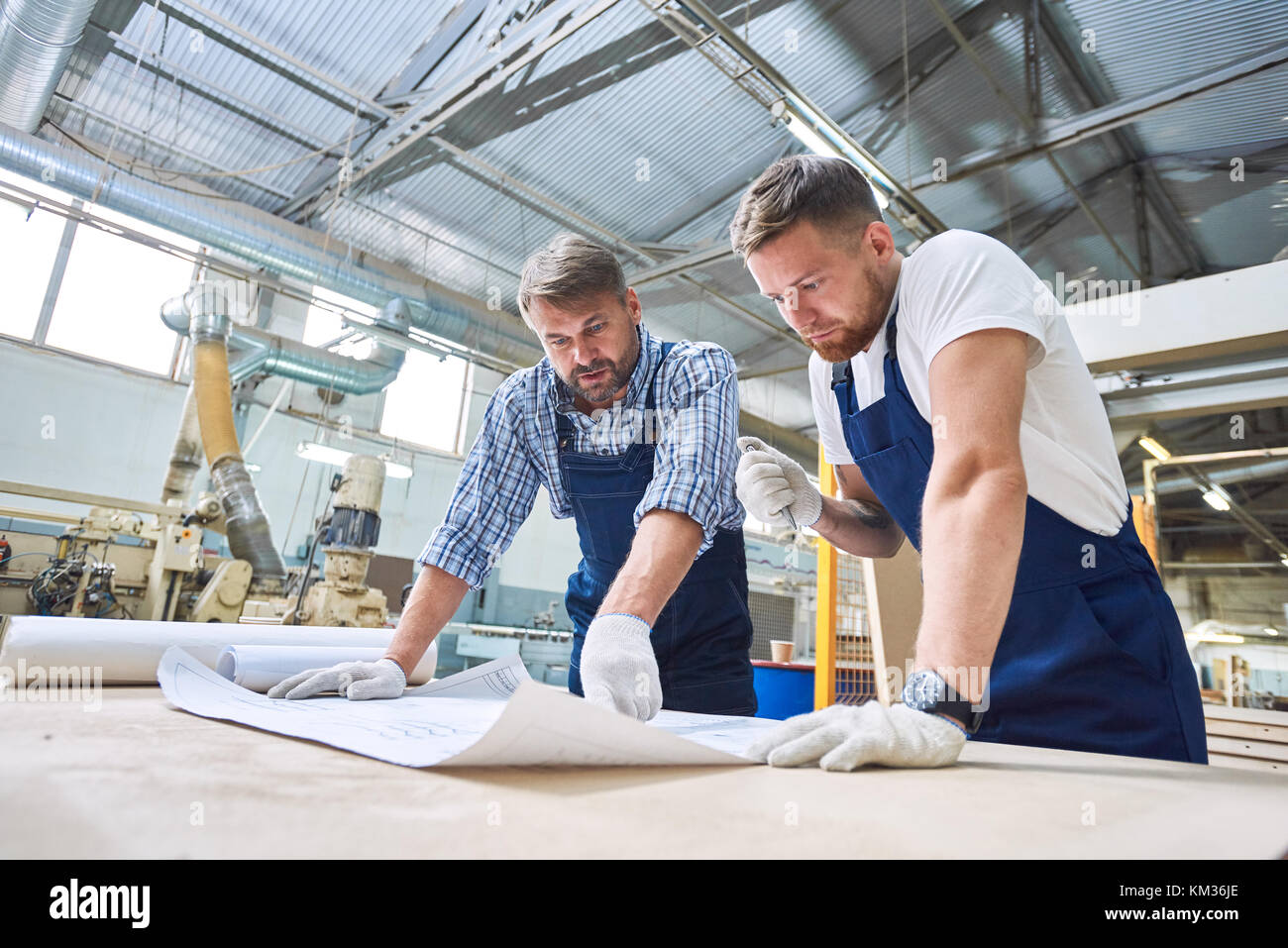 Construction Workers Looking at Plans Stock Photo - Alamy
