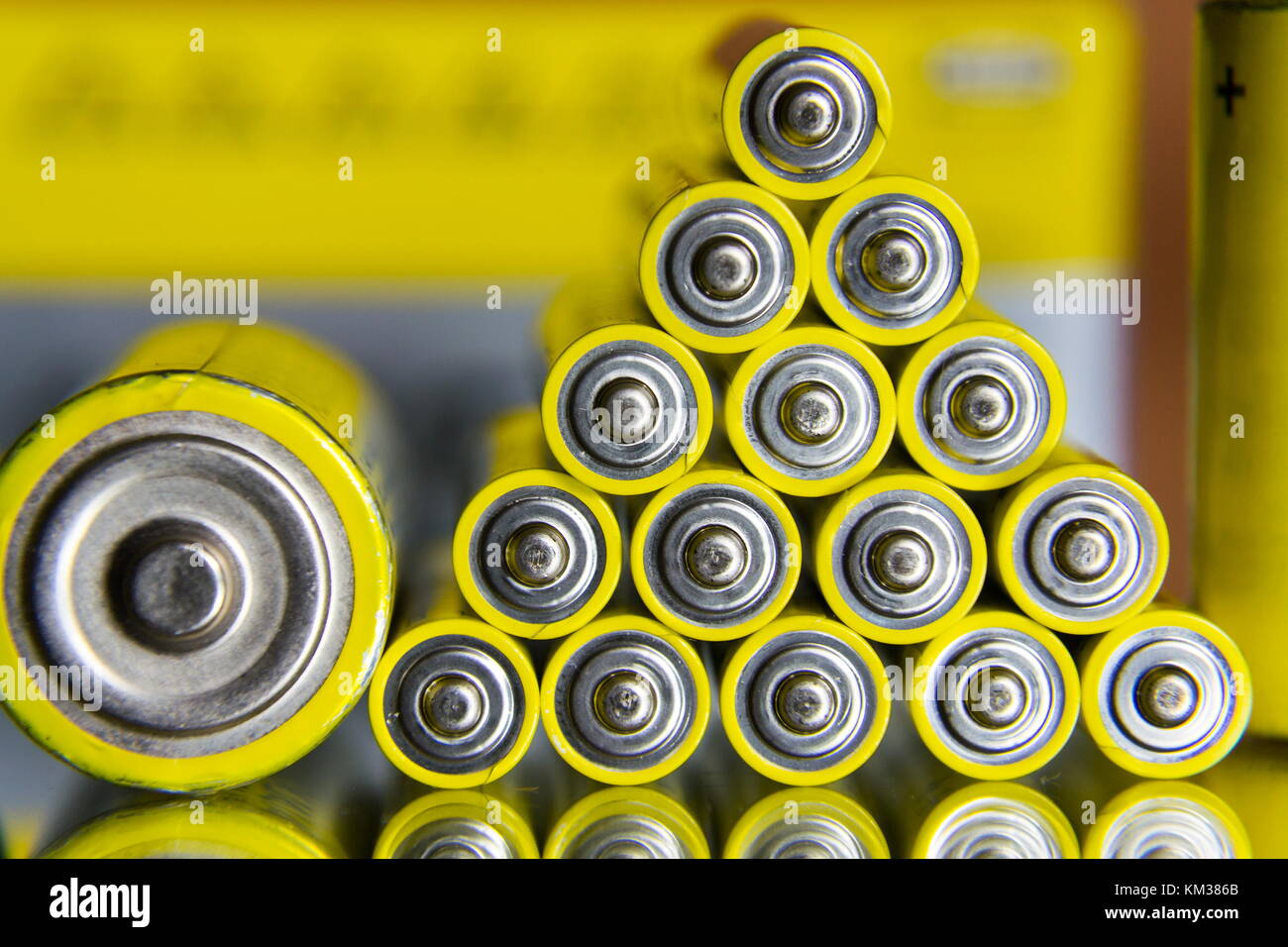 Stack of yellow AA batteries close up abstract coloured background ...