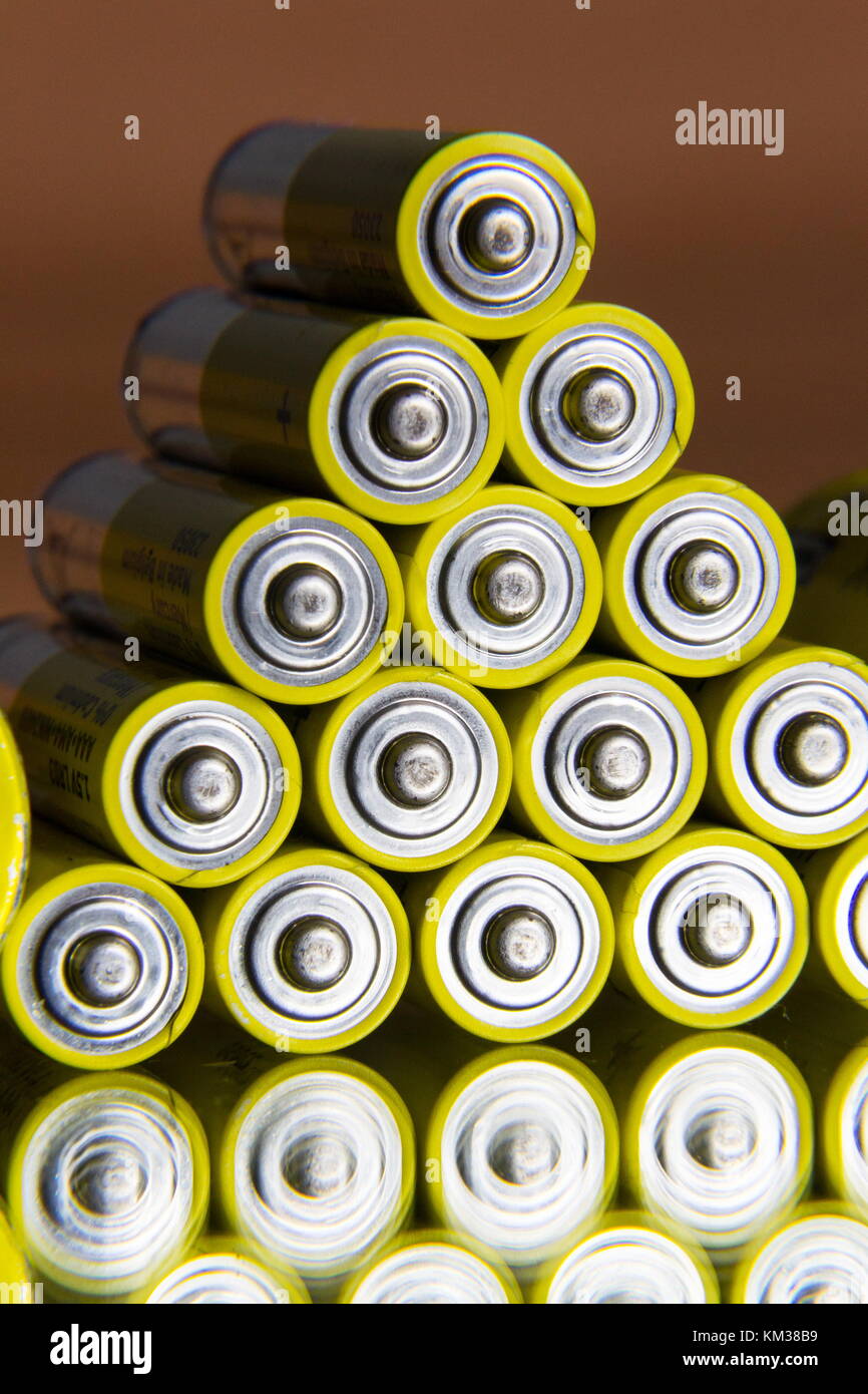 Stack of yellow AA batteries close up abstract coloured background ...