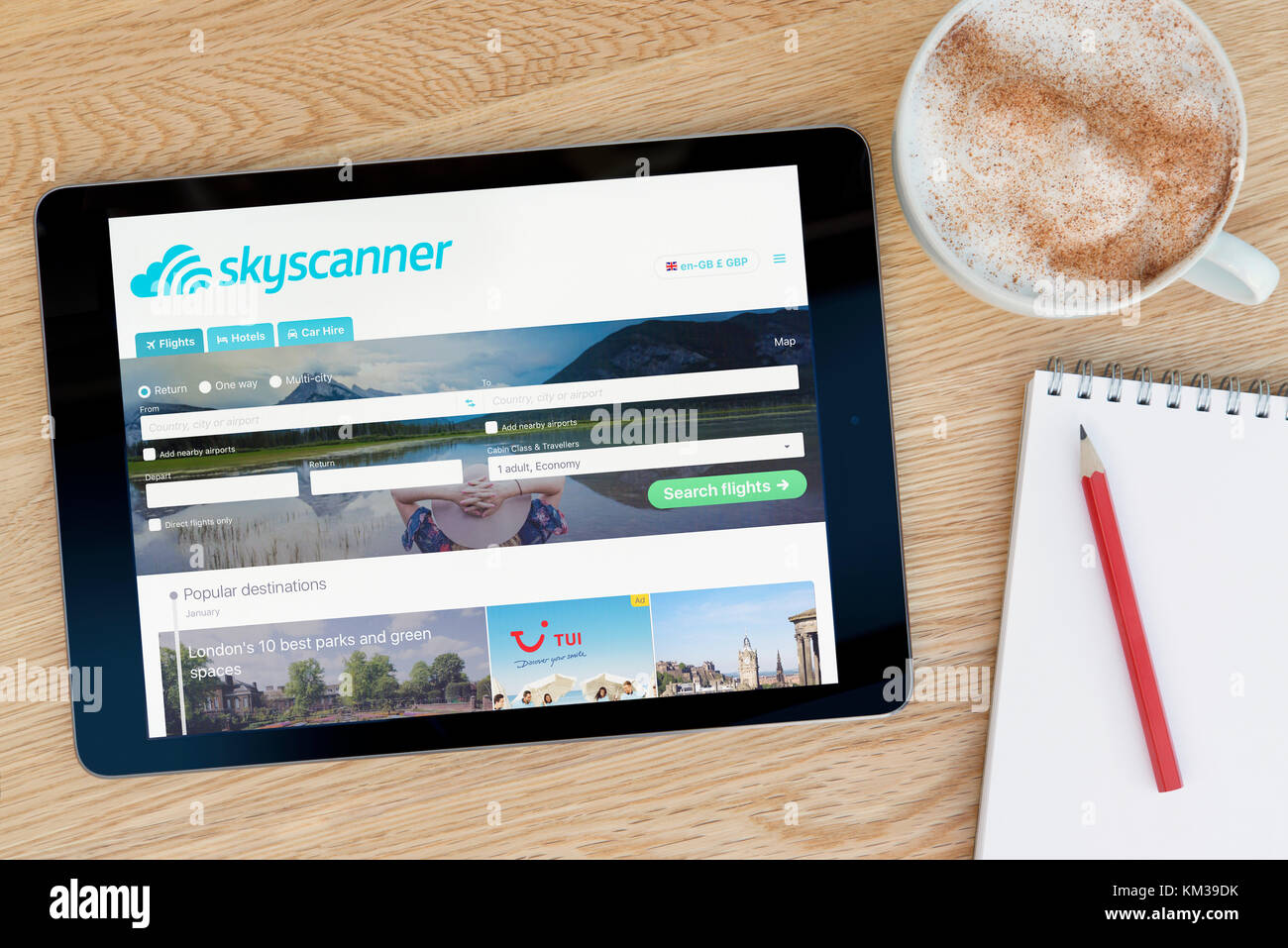The Skyscanner website features on an iPad tablet device which rests on ...