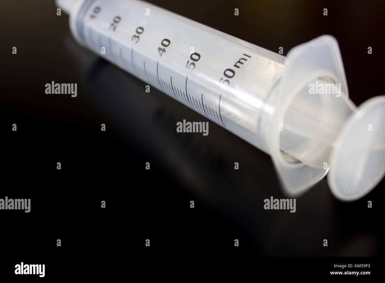 Big empty Syringe isolated on black shiny background Stock Photo - Alamy