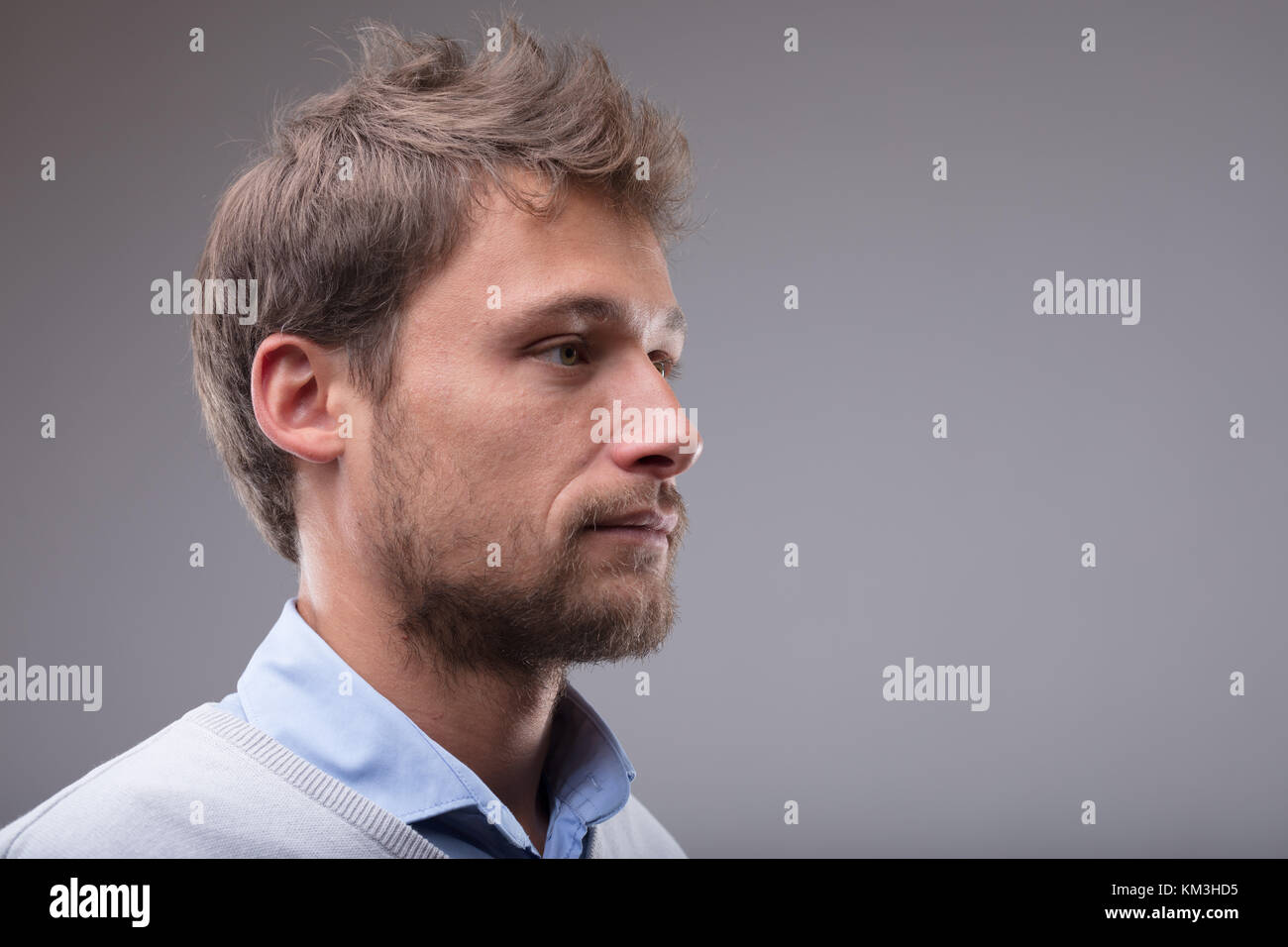 Side profile portrait of a young blond man staring straight ahead with ...
