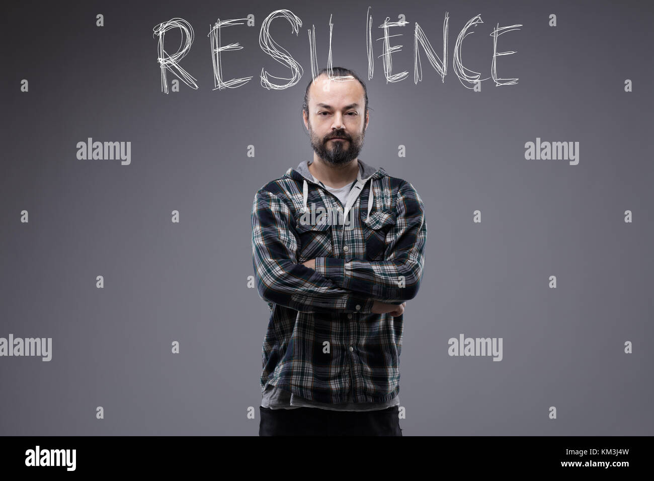 Attractive bearded man standing with folded arms and a determined ...