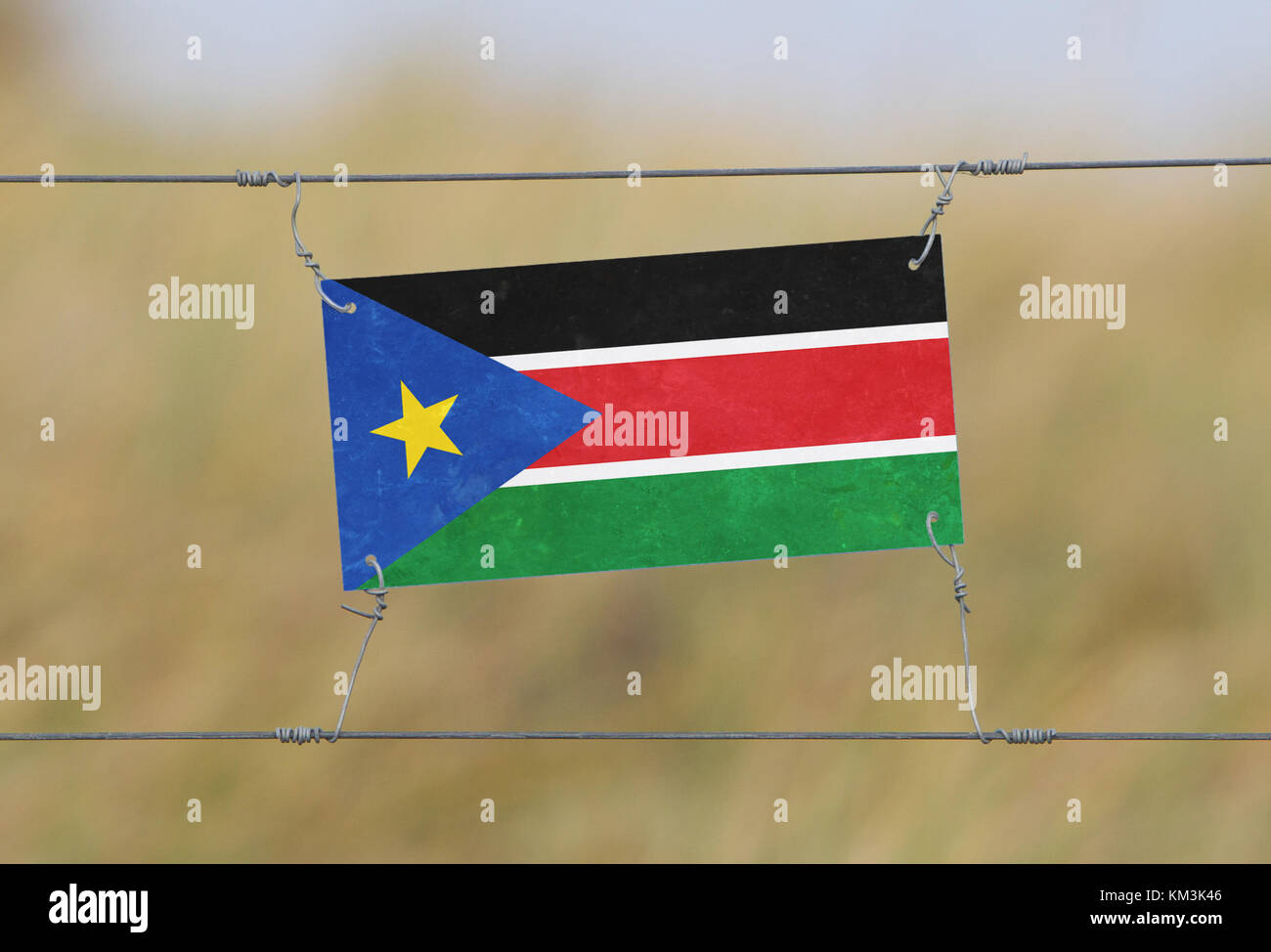 Border fence - Old plastic sign with a flag - South Sudan Stock Photo ...