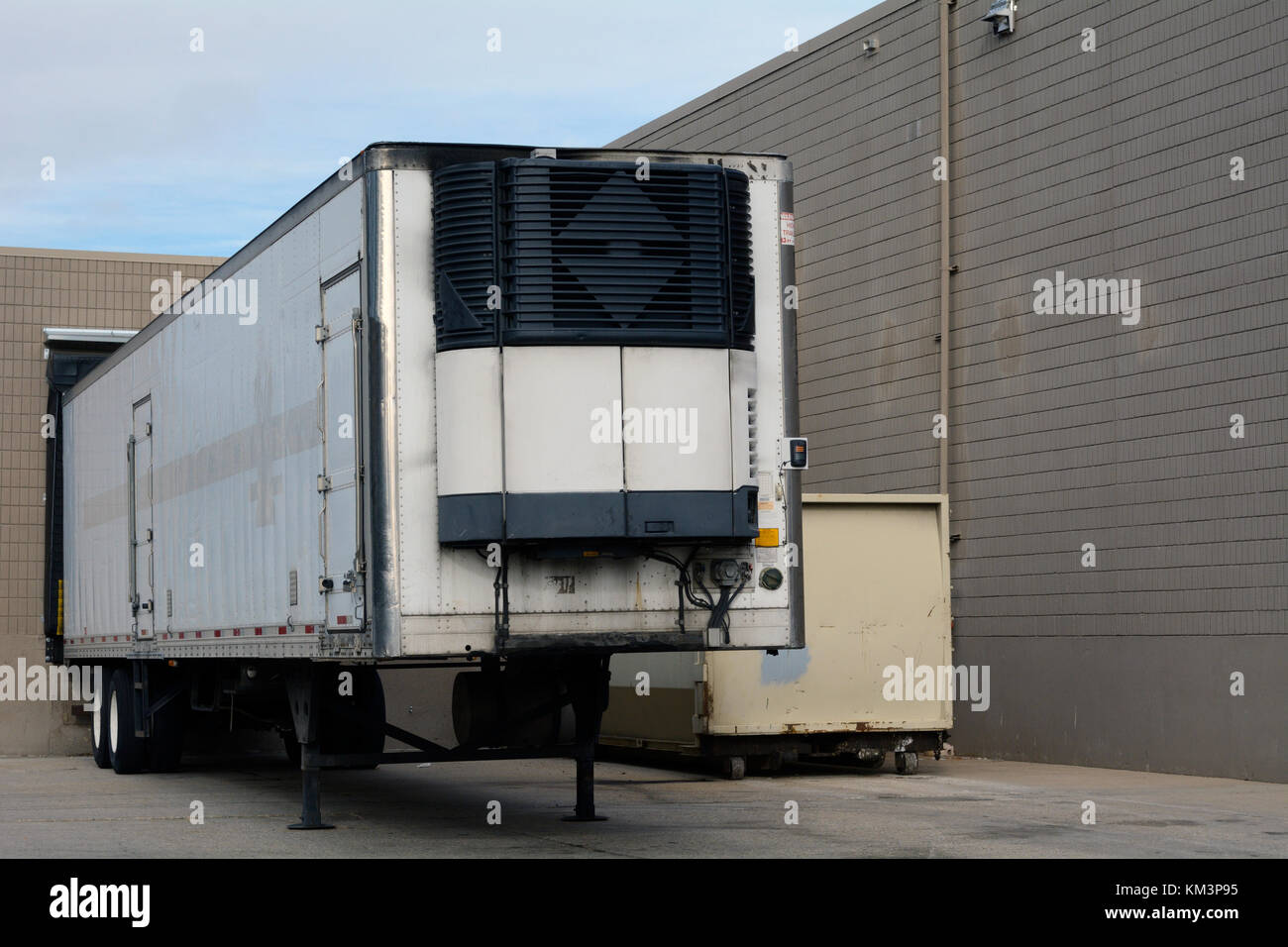 Shipping truck trailer parked at receiving door of business or grocery ...