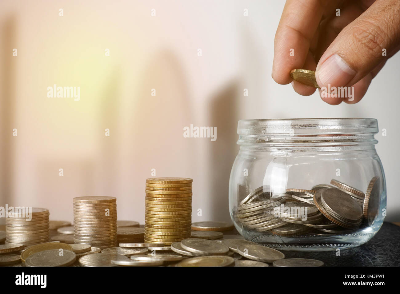 Hand putting money in jar hi-res stock photography and images - Alamy