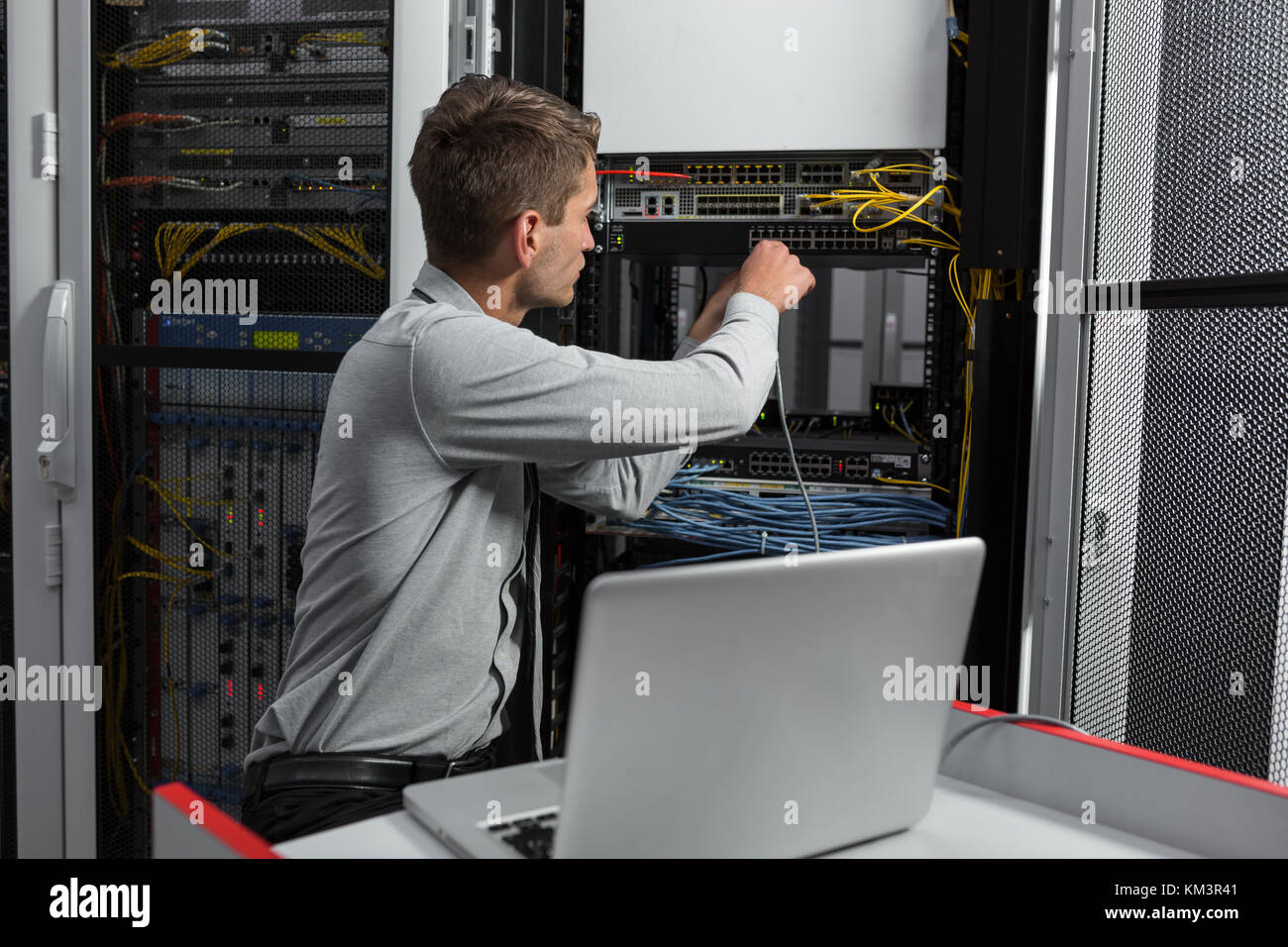 Young business man with laptop working in data center Stock Photo - Alamy