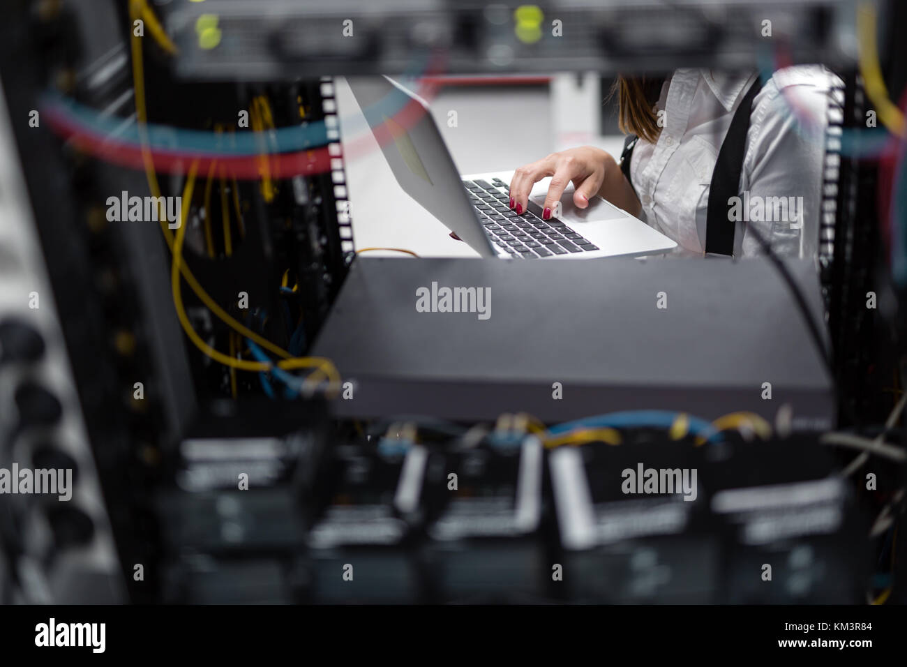 Portrait of modern young woman holding laptop standing in server room ...