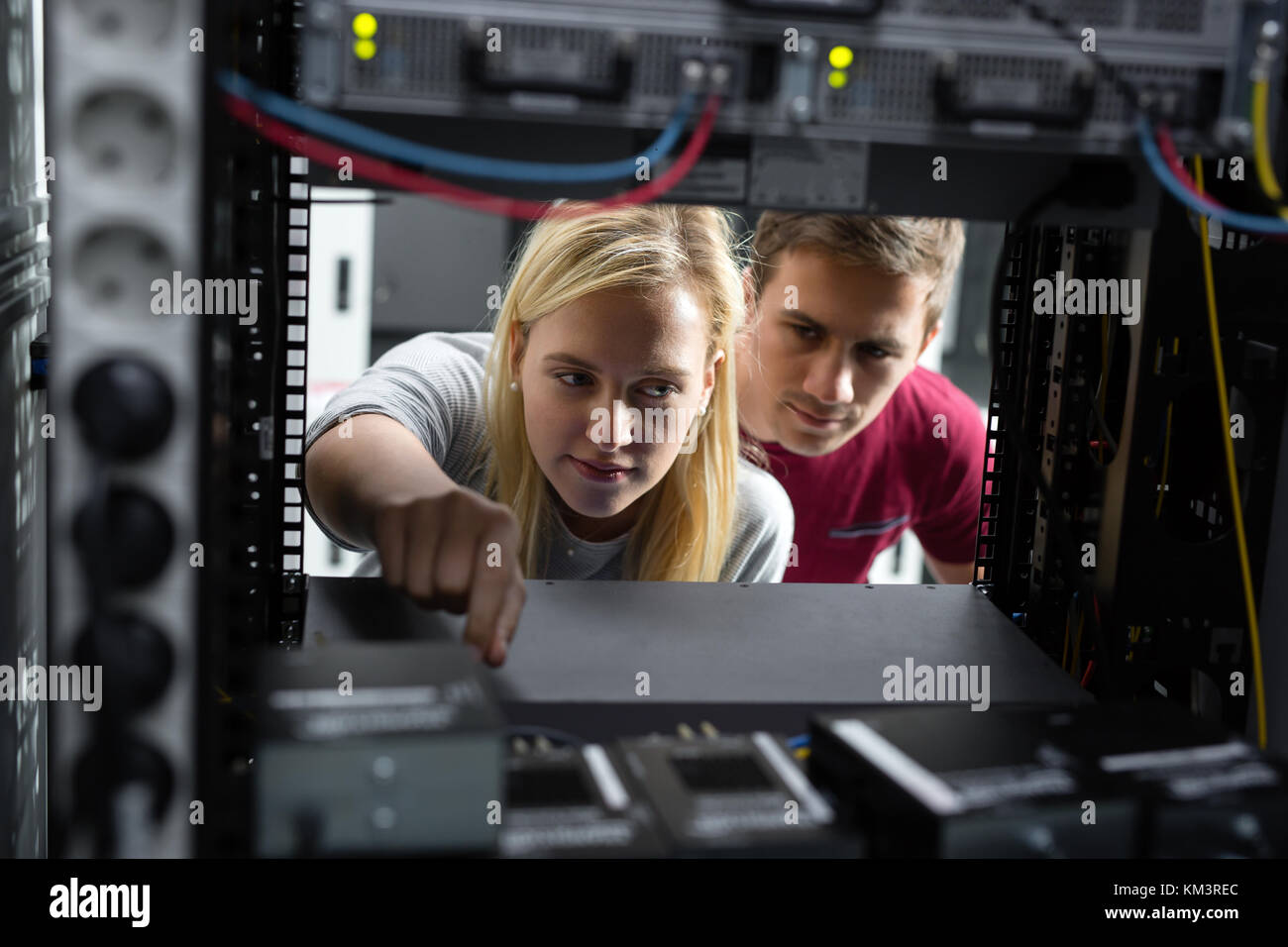 Team of technicians working together on servers at the data centre ...