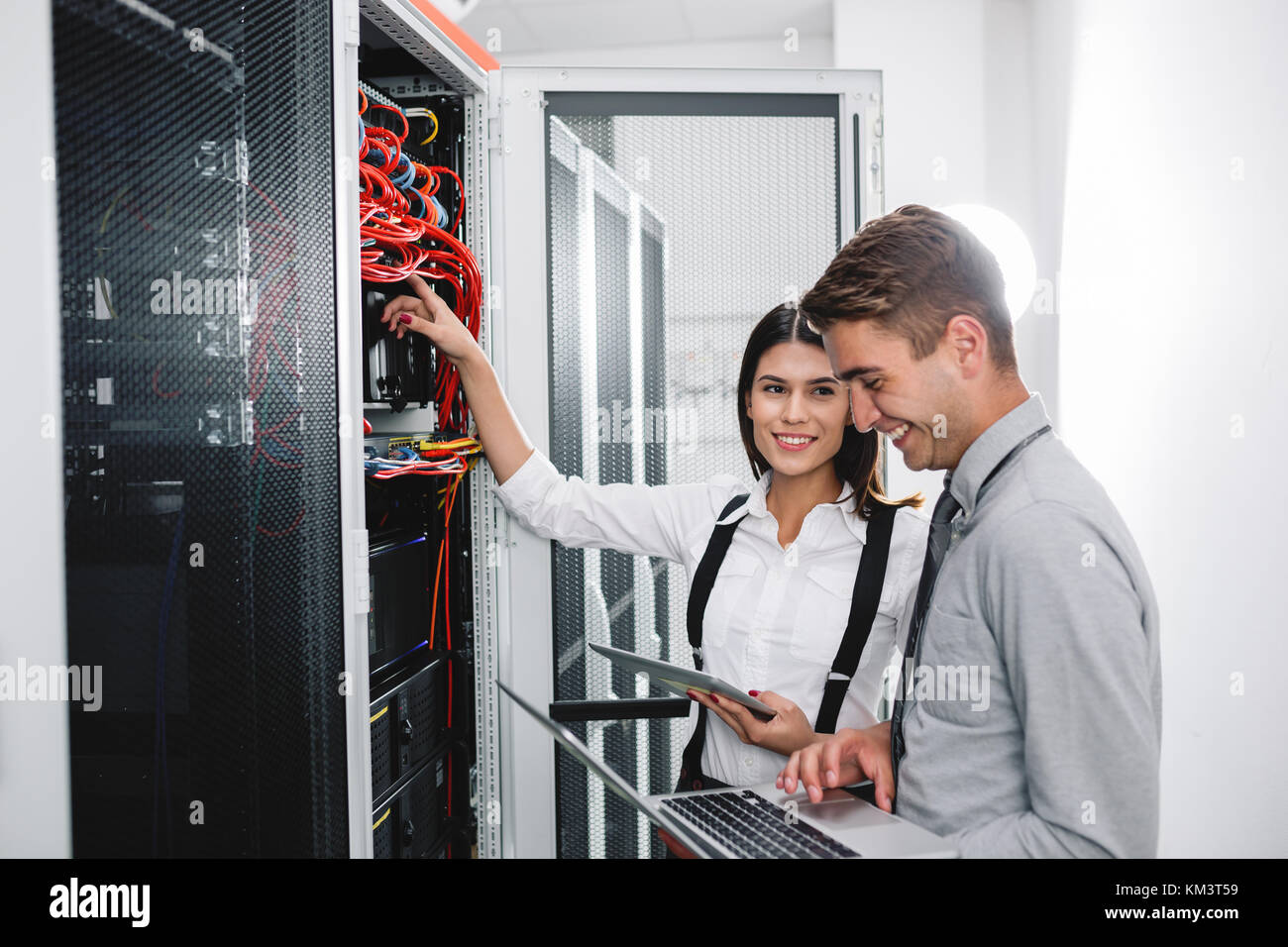 Team of technicians working together on servers at the data centre ...