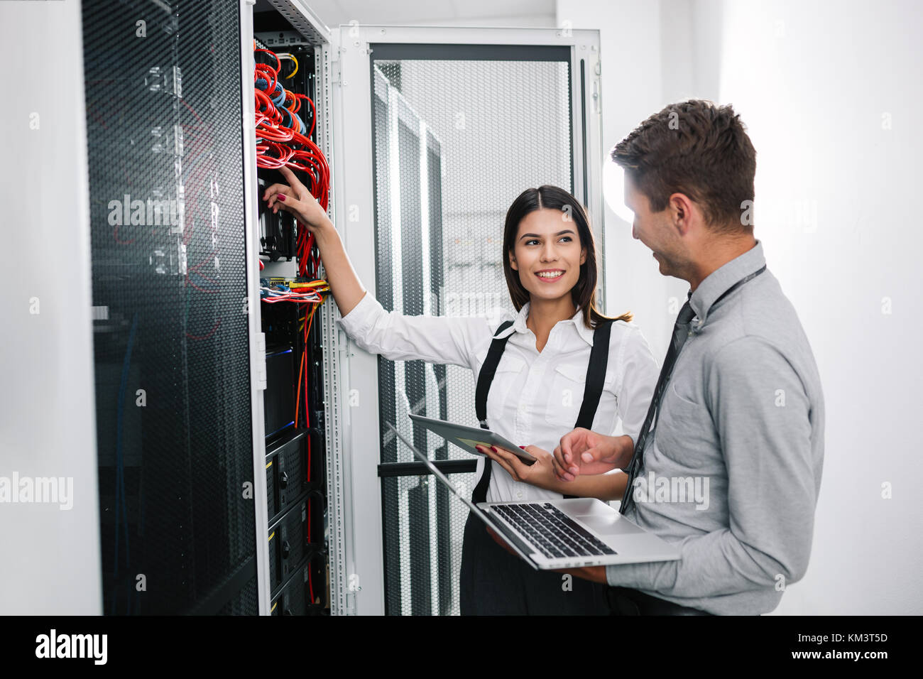 Team of technicians working together on servers at the data centre ...
