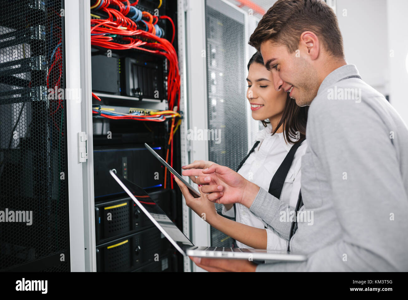 Team of technicians working together on servers at the data centre ...