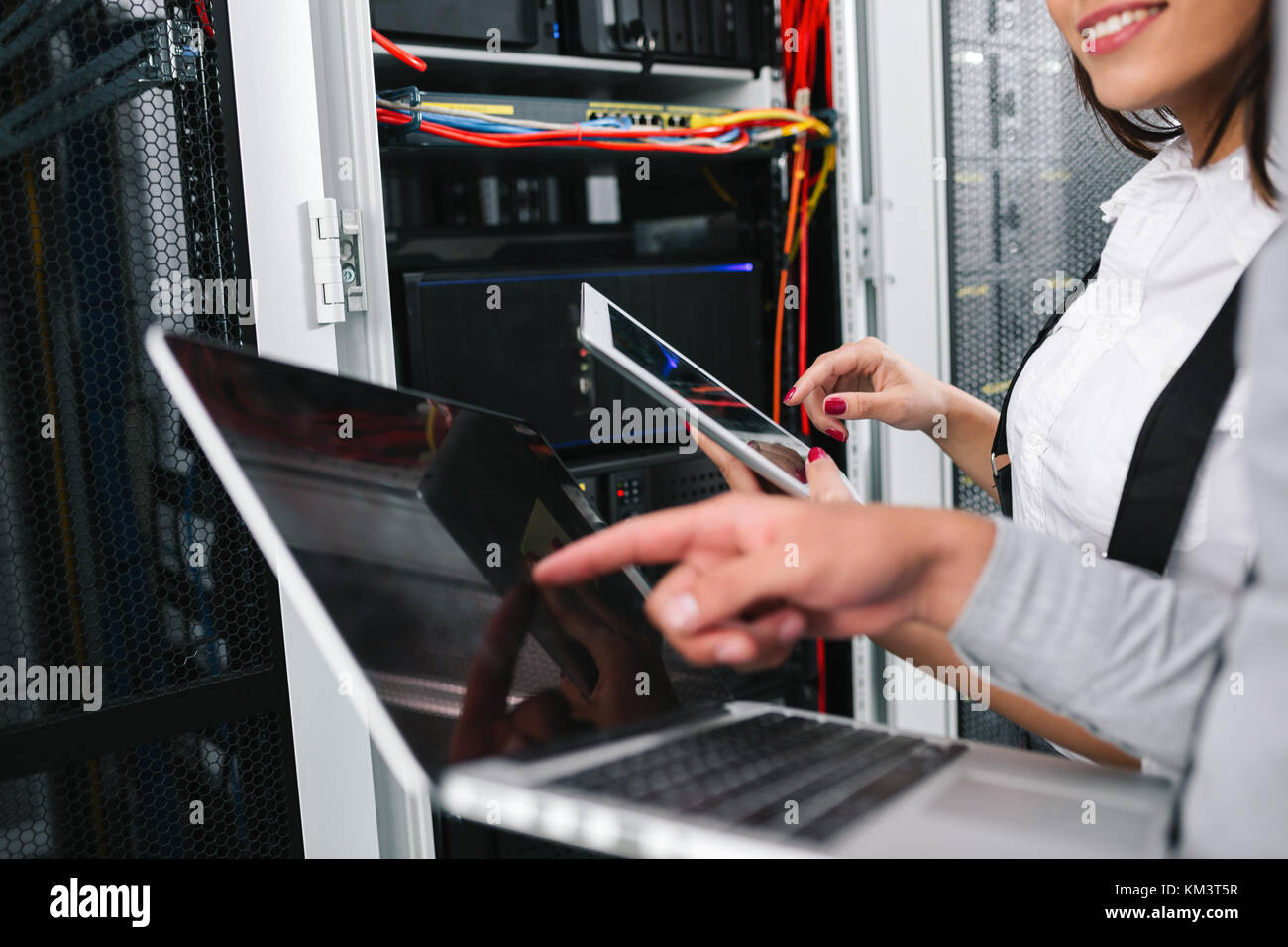 Team of technicians working together on servers at the data centre ...