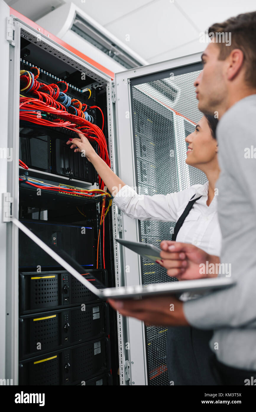 Team of technicians working together on servers at the data centre ...