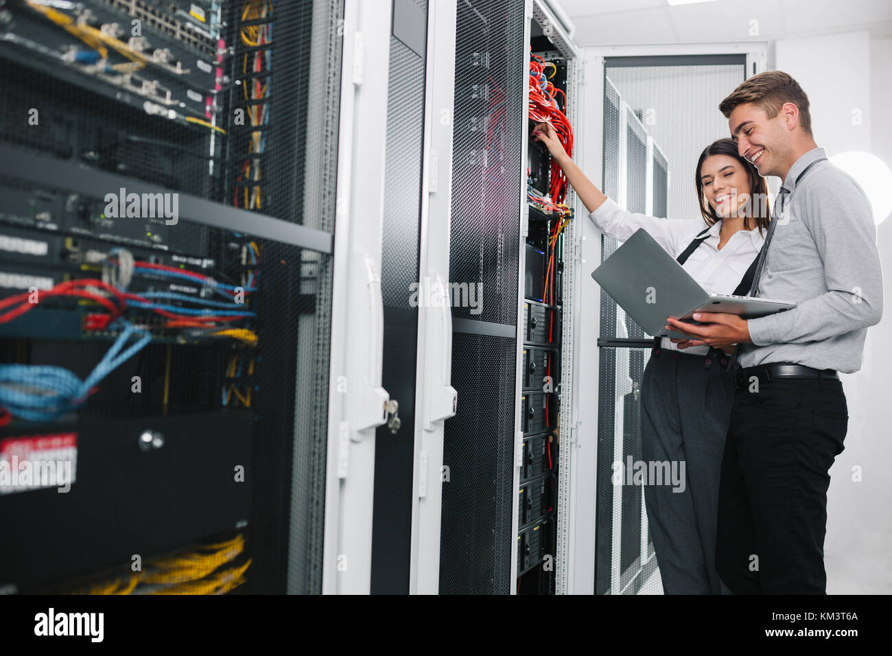Team of technicians working together on servers at the data centre ...
