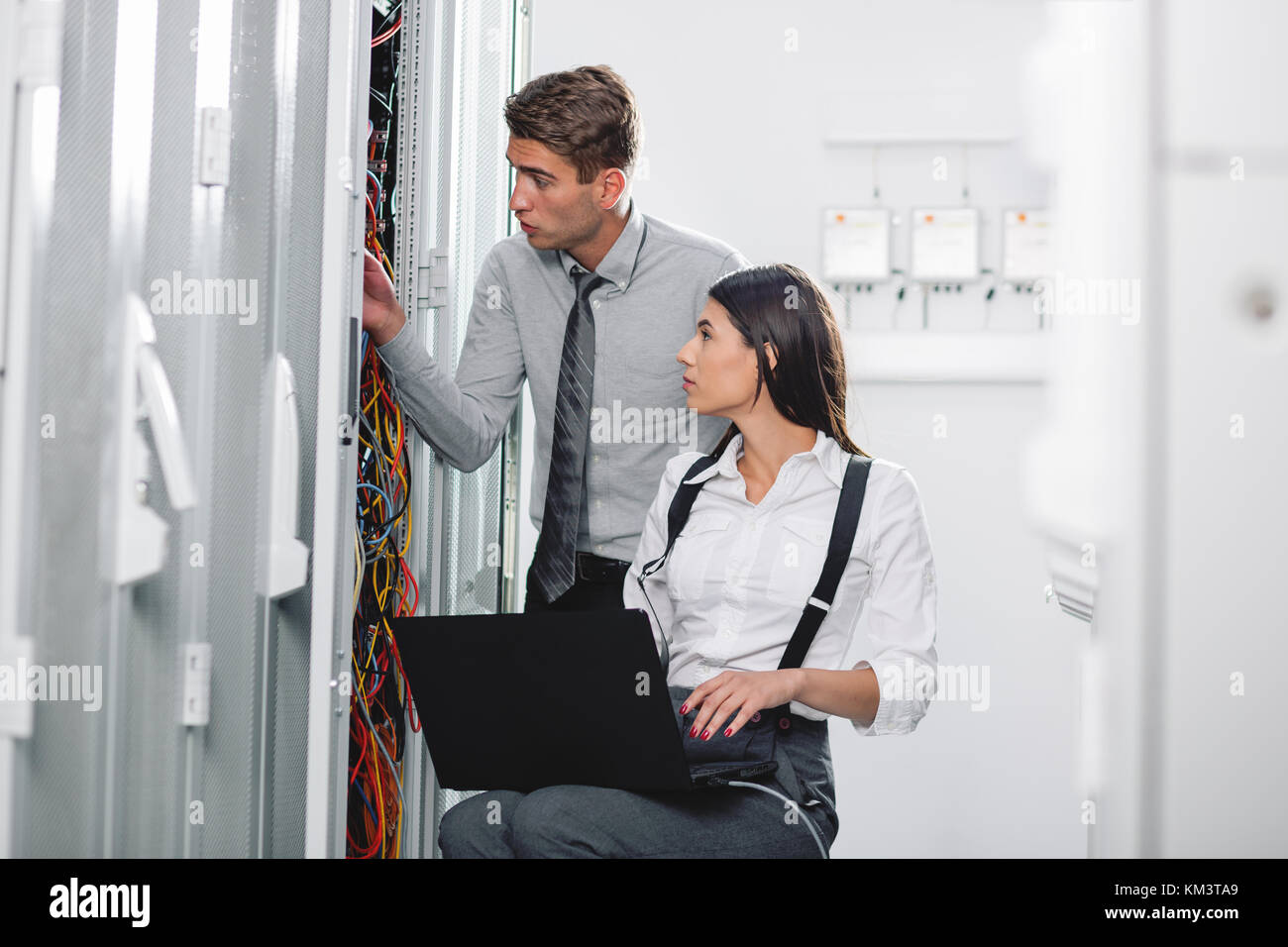 Team of technicians working together on servers at the data centre ...