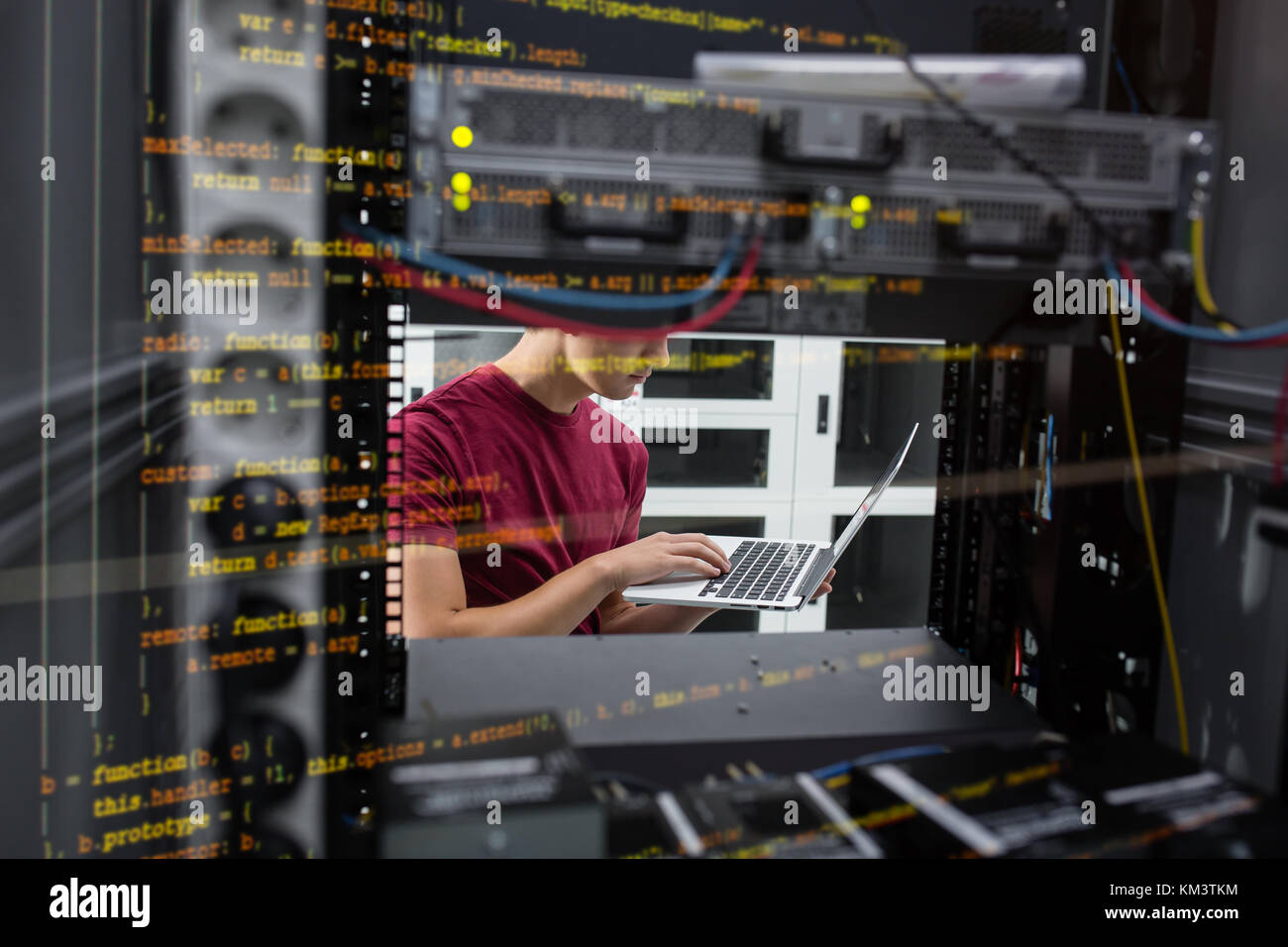 Portrait of modern young man holding laptop standing in server room ...