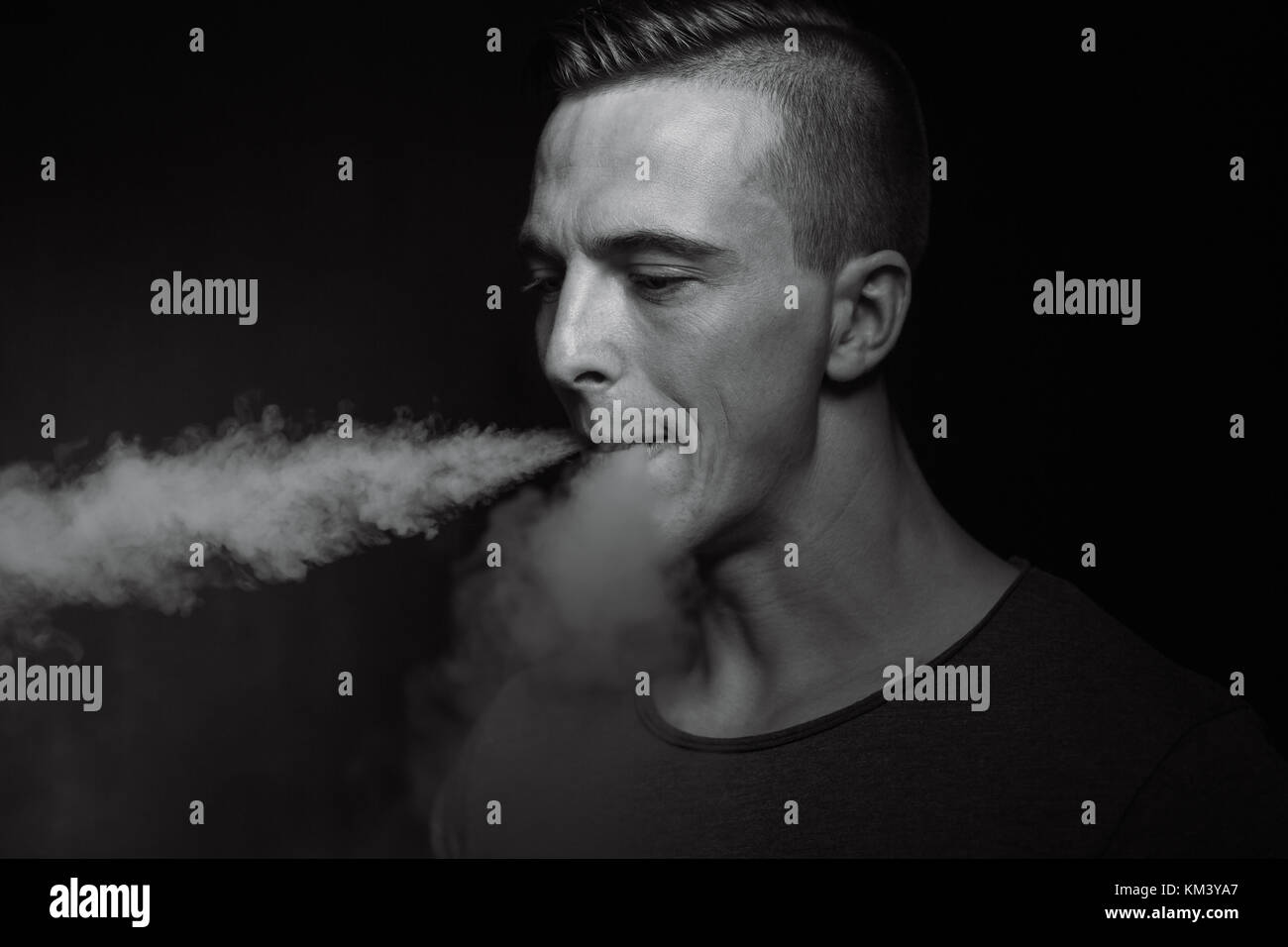 Men on black background vaping and releases a cloud of vapor Stock ...