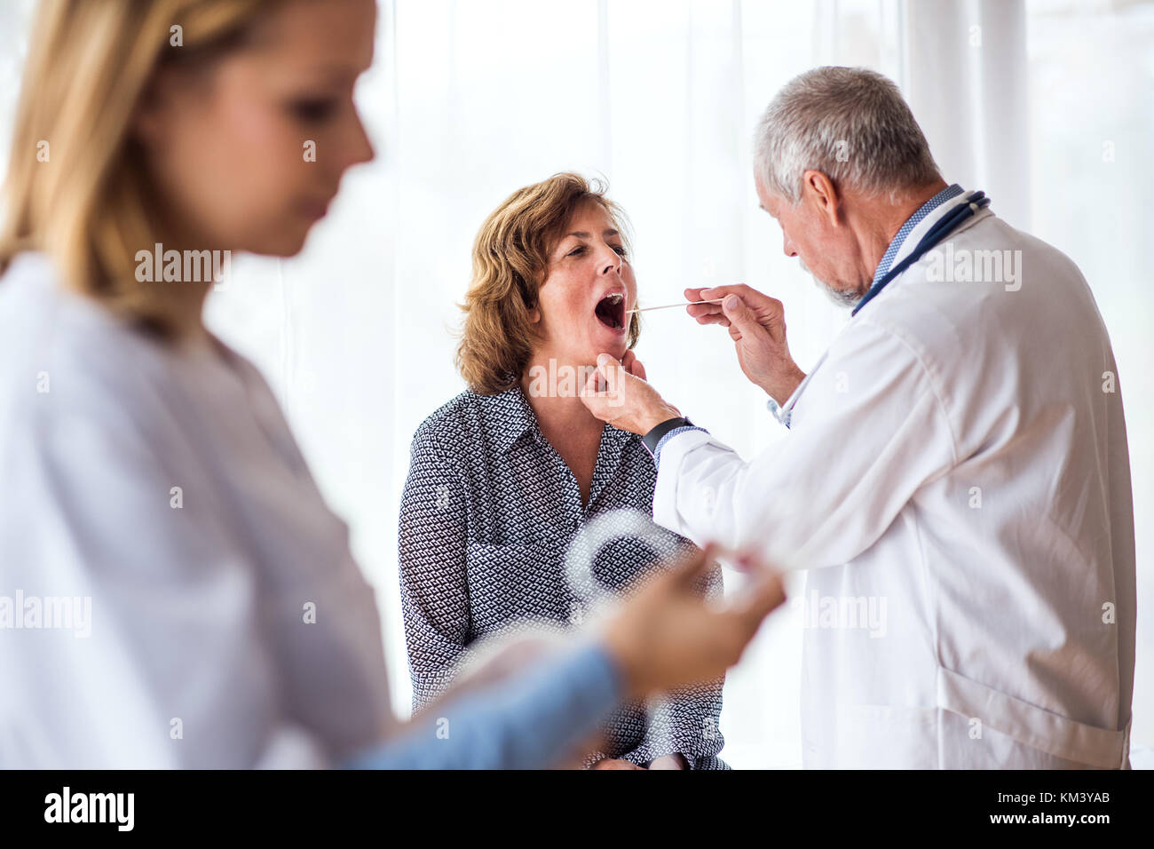 Senior doctor examining a senior woman in office Stock Photo - Alamy