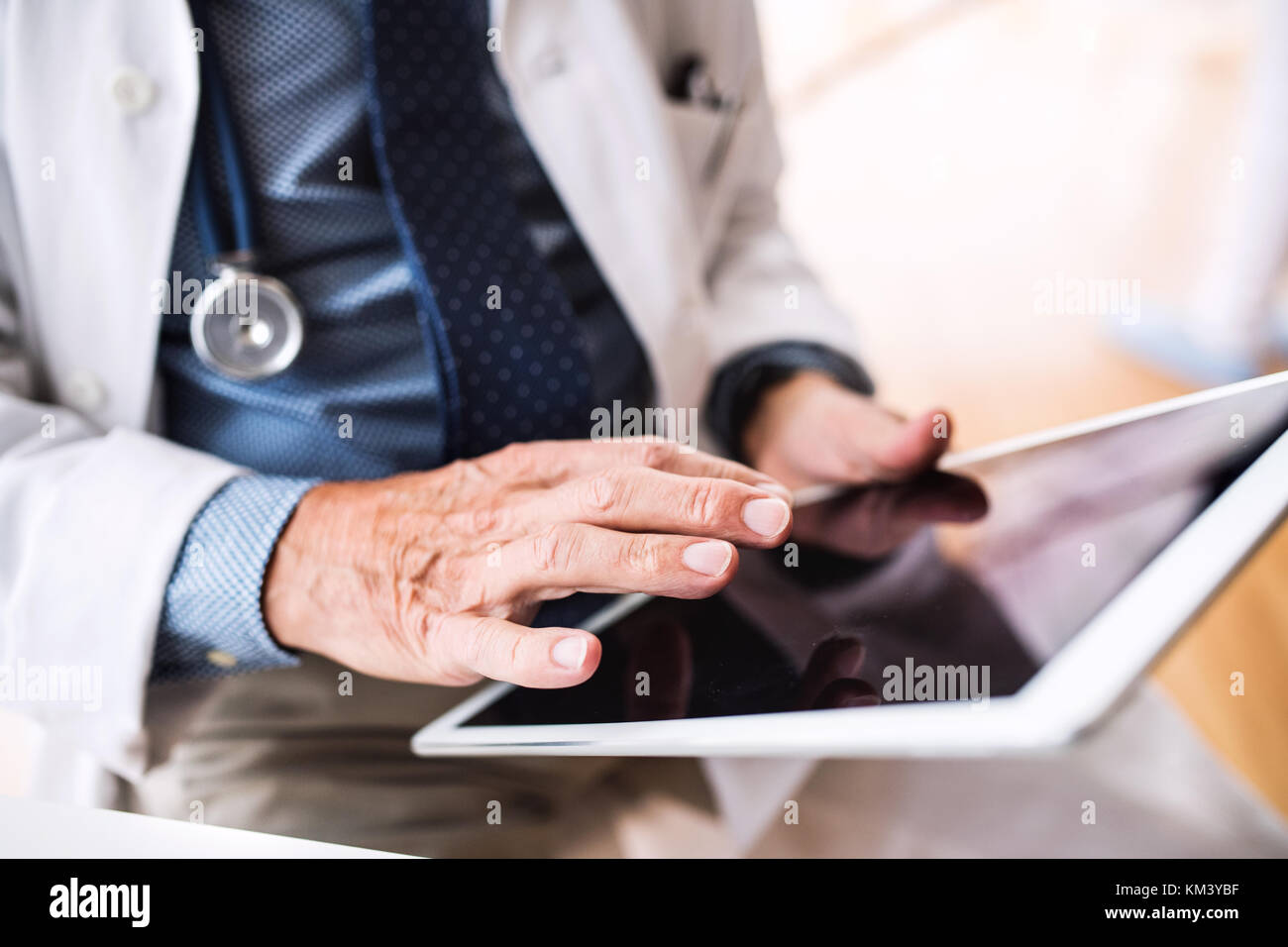 Senior doctor with tablet working at the office Stock Photo - Alamy