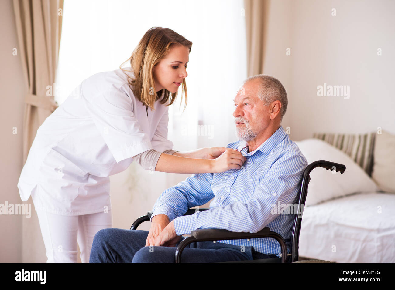 Nurse and senior man in wheelchair during home visit Stock Photo - Alamy