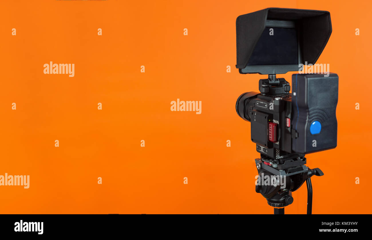 Professional video camera on vivid color background making contrast ...