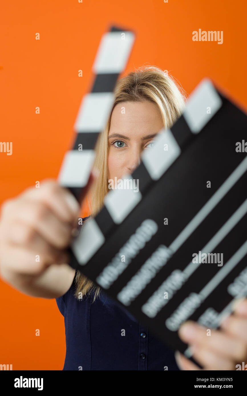 Young woman in action, holding clapperboard. Cinema concept Stock Photo ...