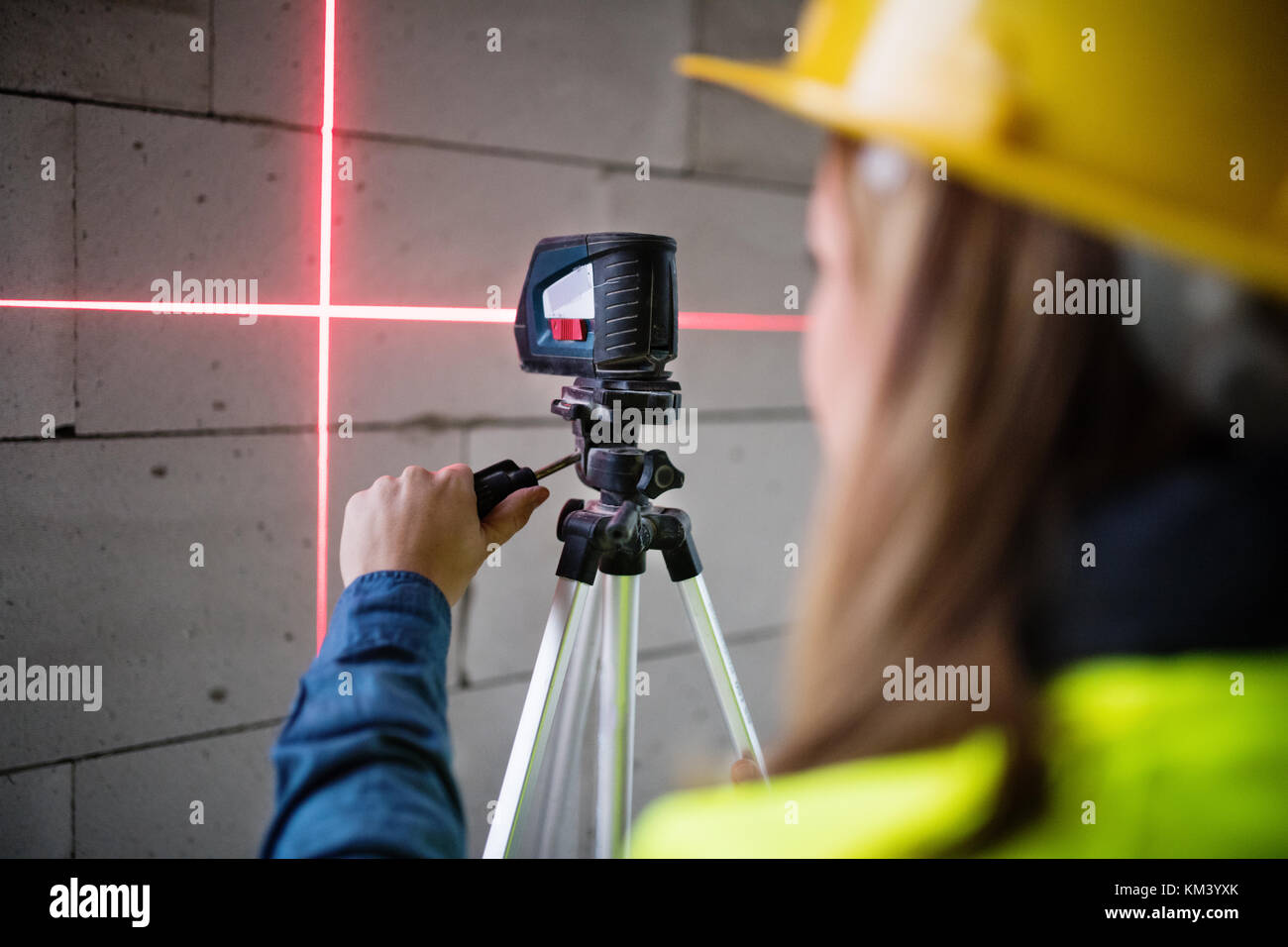 Young woman worker with laser on the building site Stock Photo - Alamy