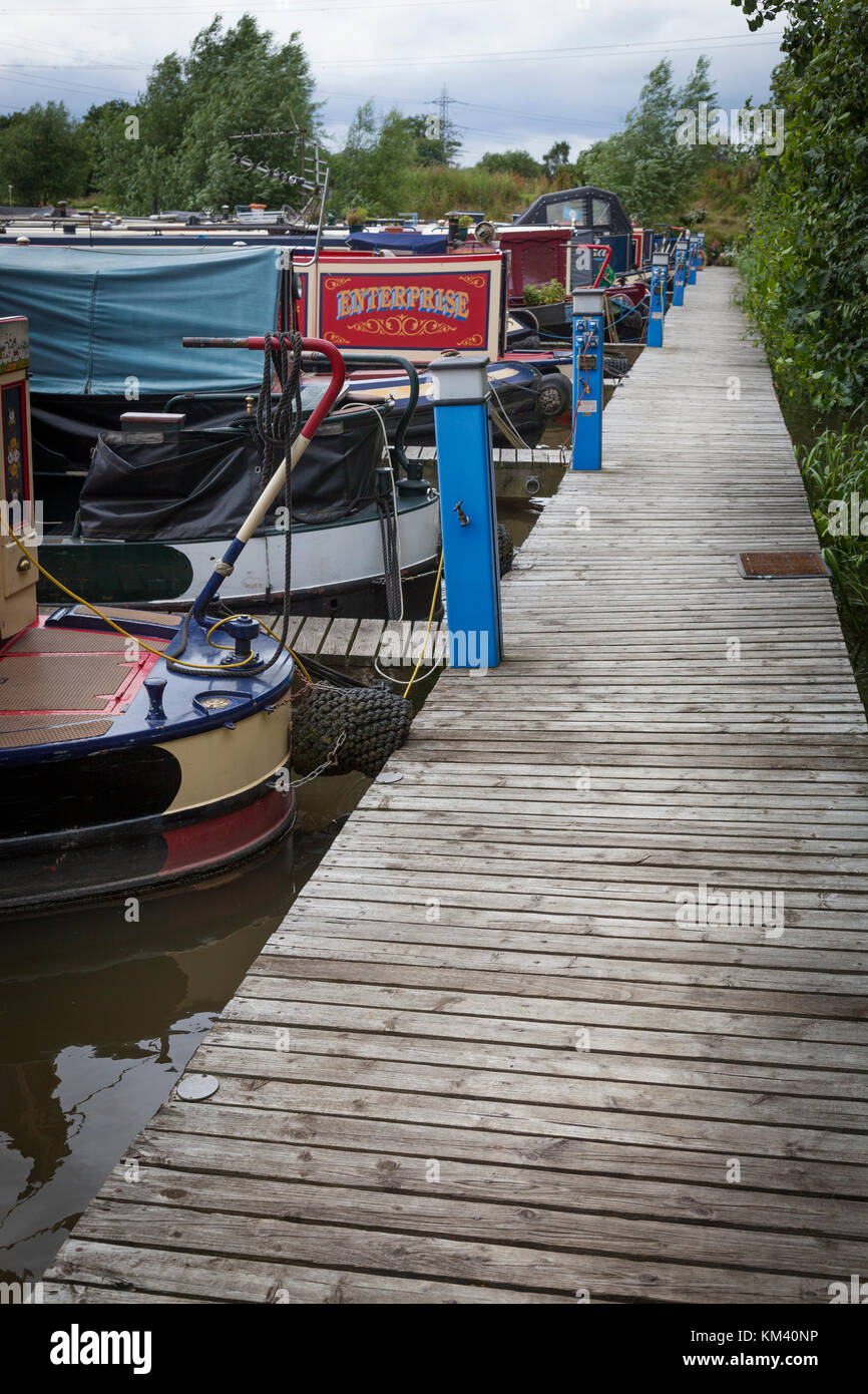 Narrowboats moored and services attached at a floating wooden pontoon ...