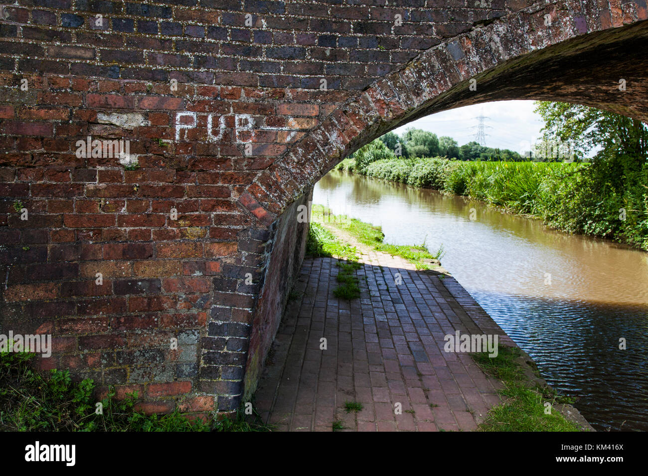 Hand painted sign for the nearest pub painted on the wall of a canal ...