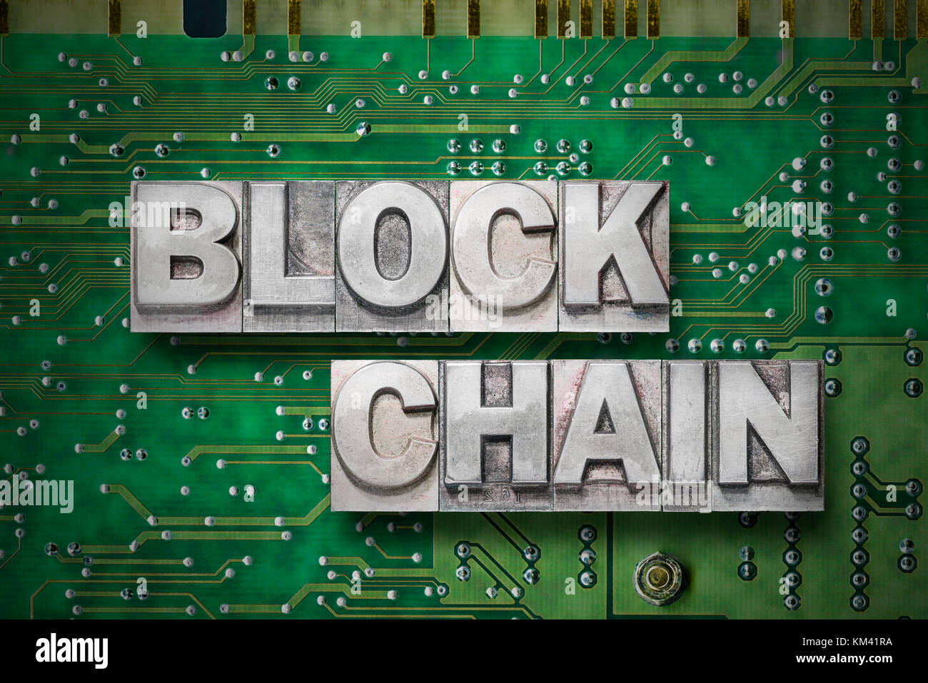 blockchain word made from metallic letterpress blocks on green pc board ...