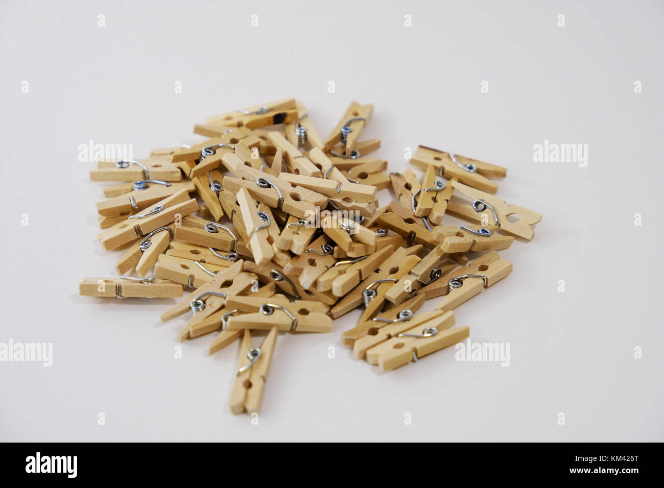 Tiny wooden laundry clips on a white background Stock Photo - Alamy