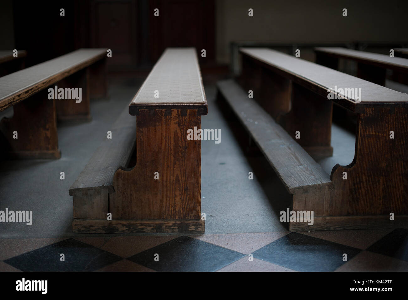 Old church wooden benches with poor light in empty church in Zagreb ...