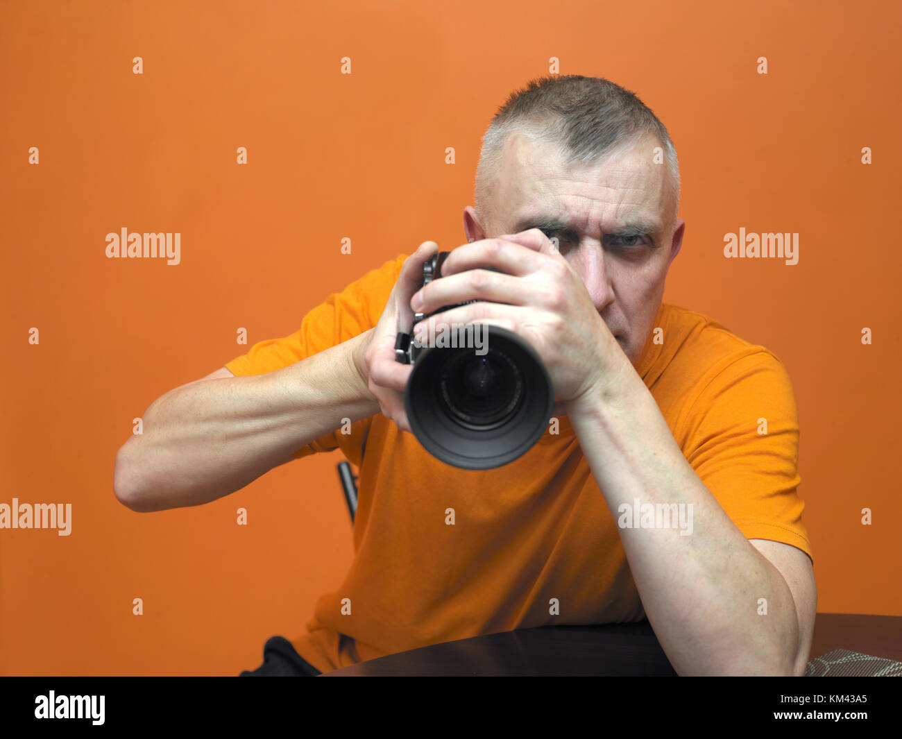 A seriously looking man pointing a photo camera, indoor portrait Stock ...