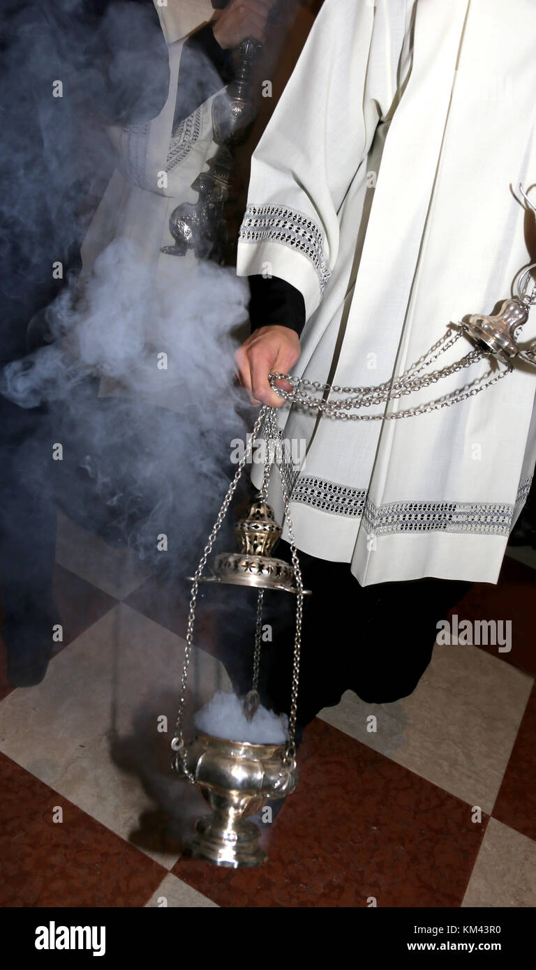 Christian priest blessing with incense in the church during Holy Mass ...