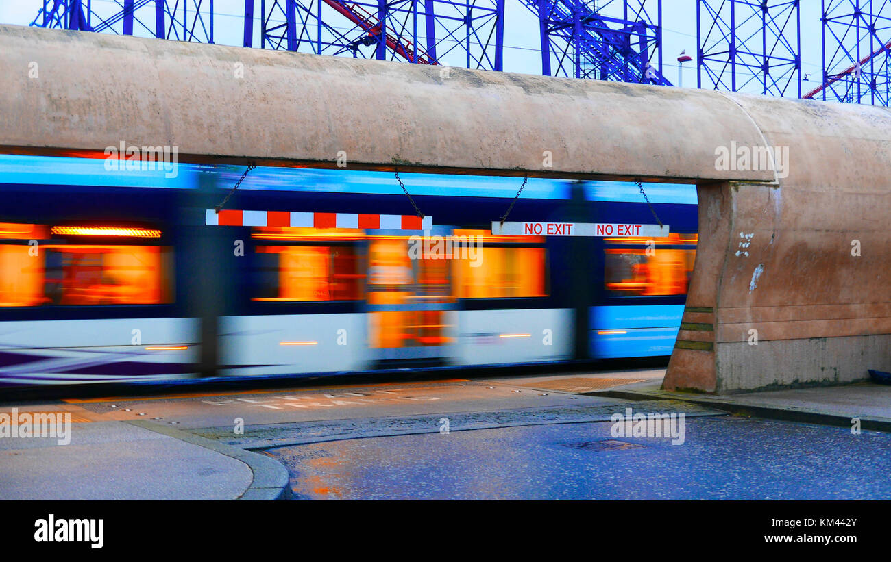 Moving tram passing concrete wall at the Pleasure Beach,Blackpool ...