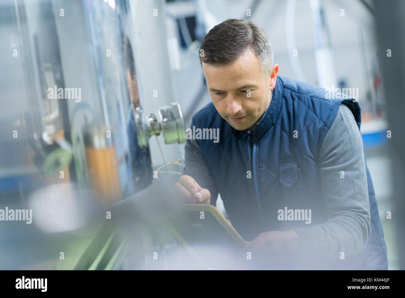 maintenance worker writing on clipboard at brewery Stock Photo - Alamy