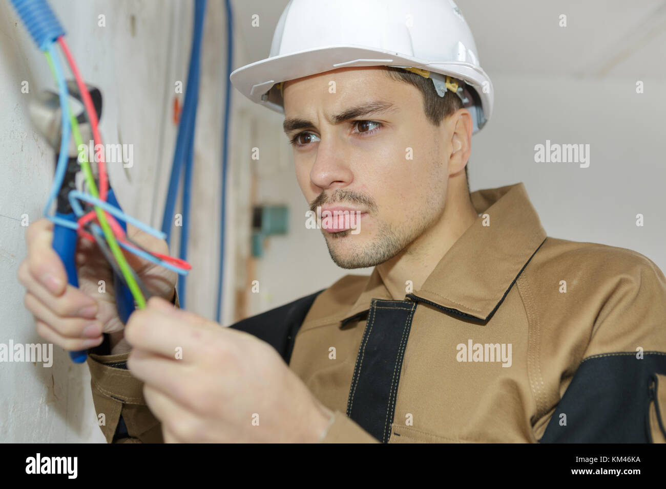 electrician attaching wires to socket in new building Stock Photo - Alamy